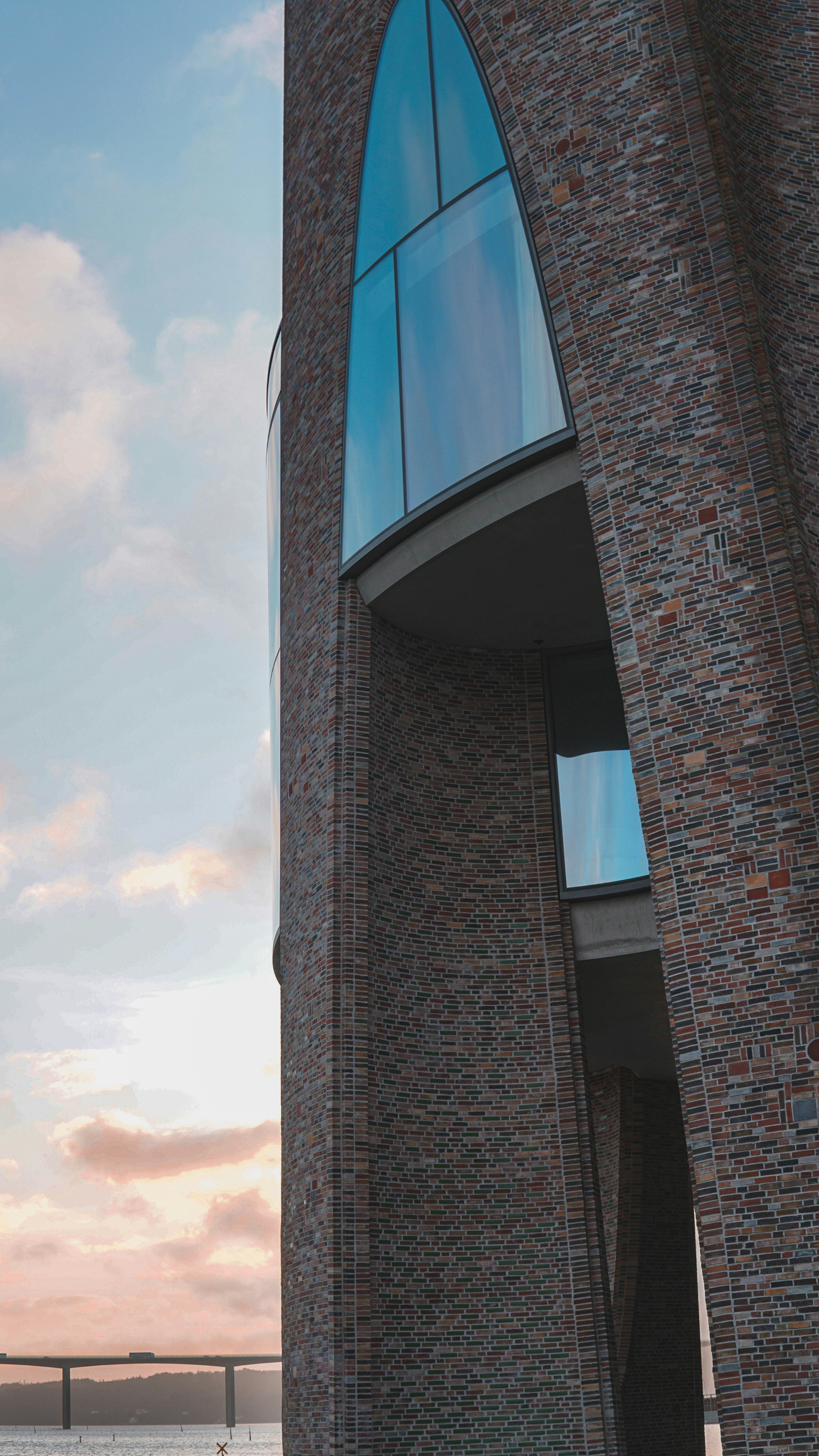 A shot of the fjordenhus in Vejle, Denmark | brown brick building under white clouds during daytime