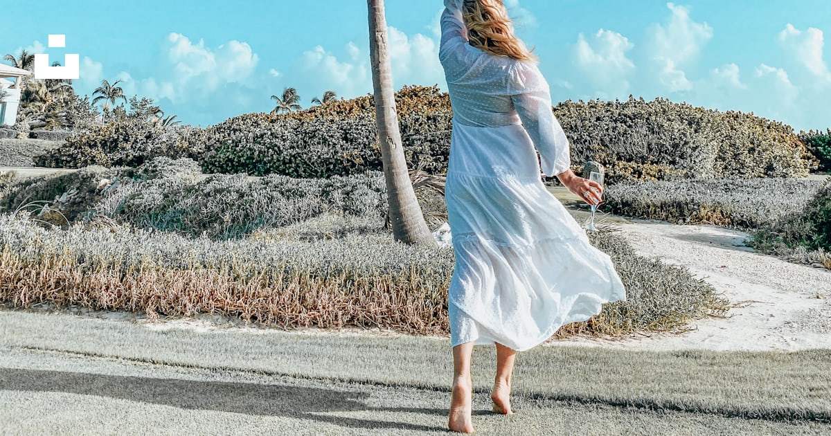 Foto Mujer Vestida De Blanco Parada Cerca De Una Palmera Durante El Día