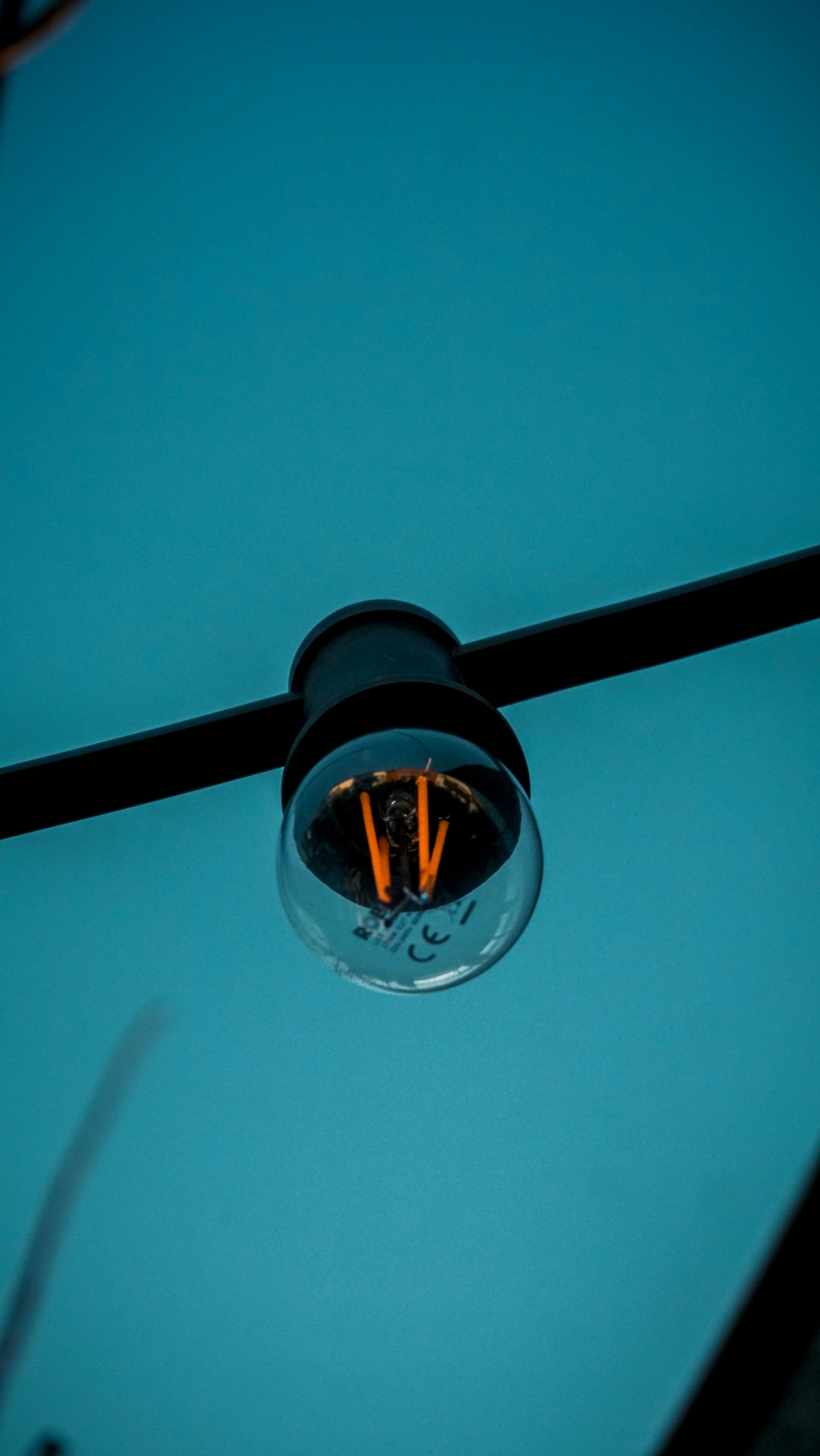 Glow in the Glass: A Single Bulb on a Teal Skyline