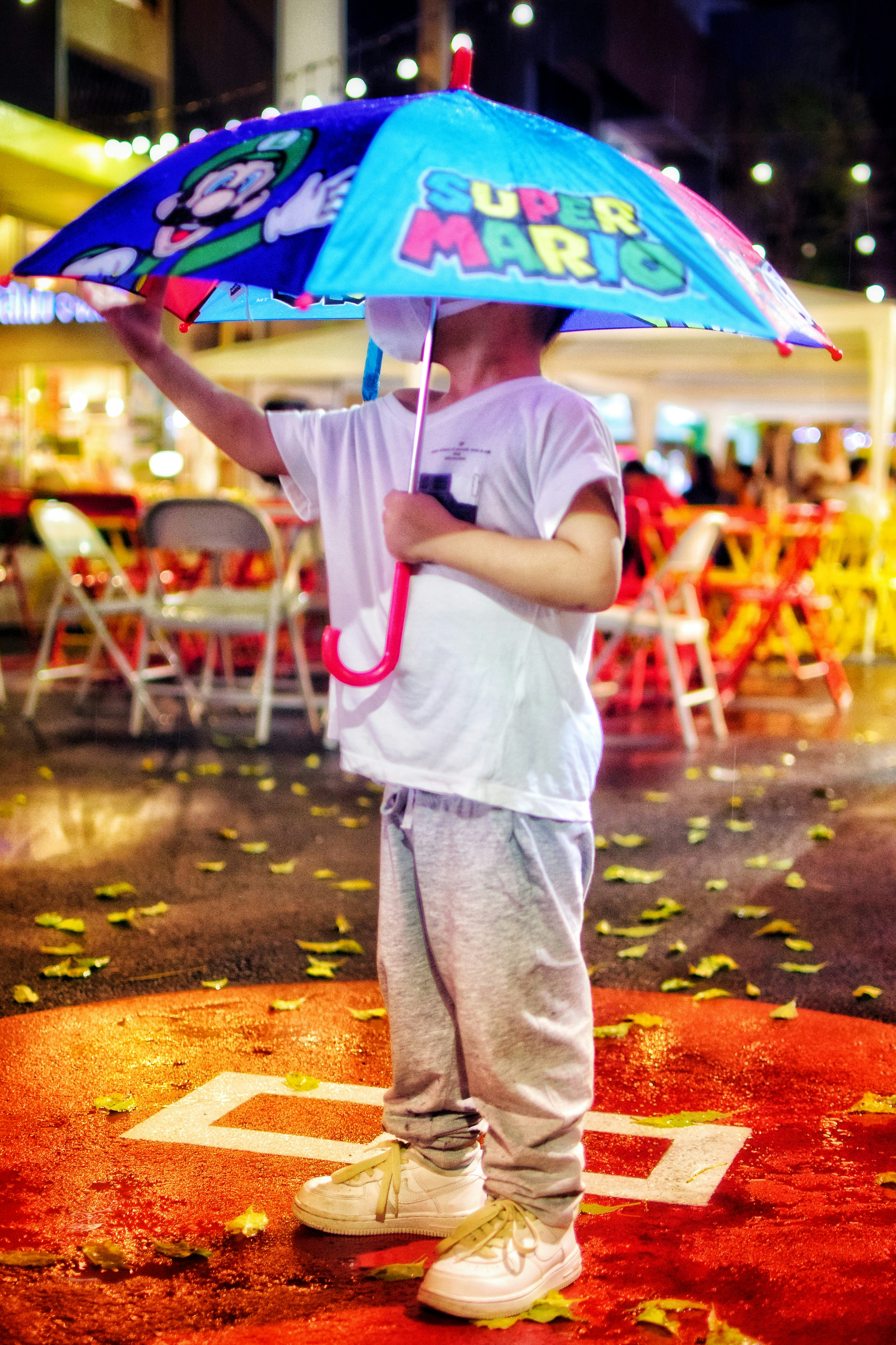 girl in white t-shirt and pants holding umbrella