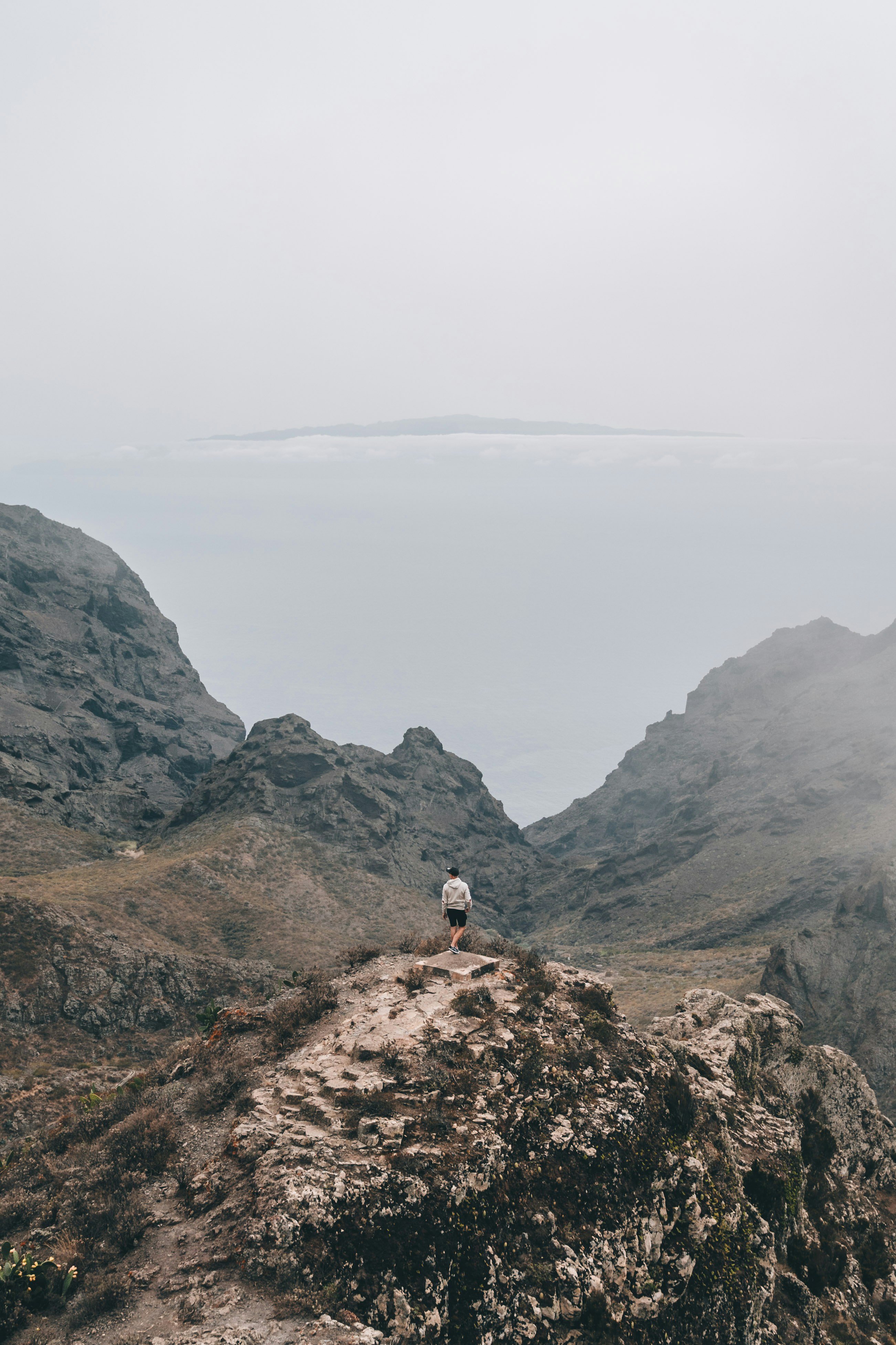 Edge of the World: a lone hiker on a jagged ridge above the sea