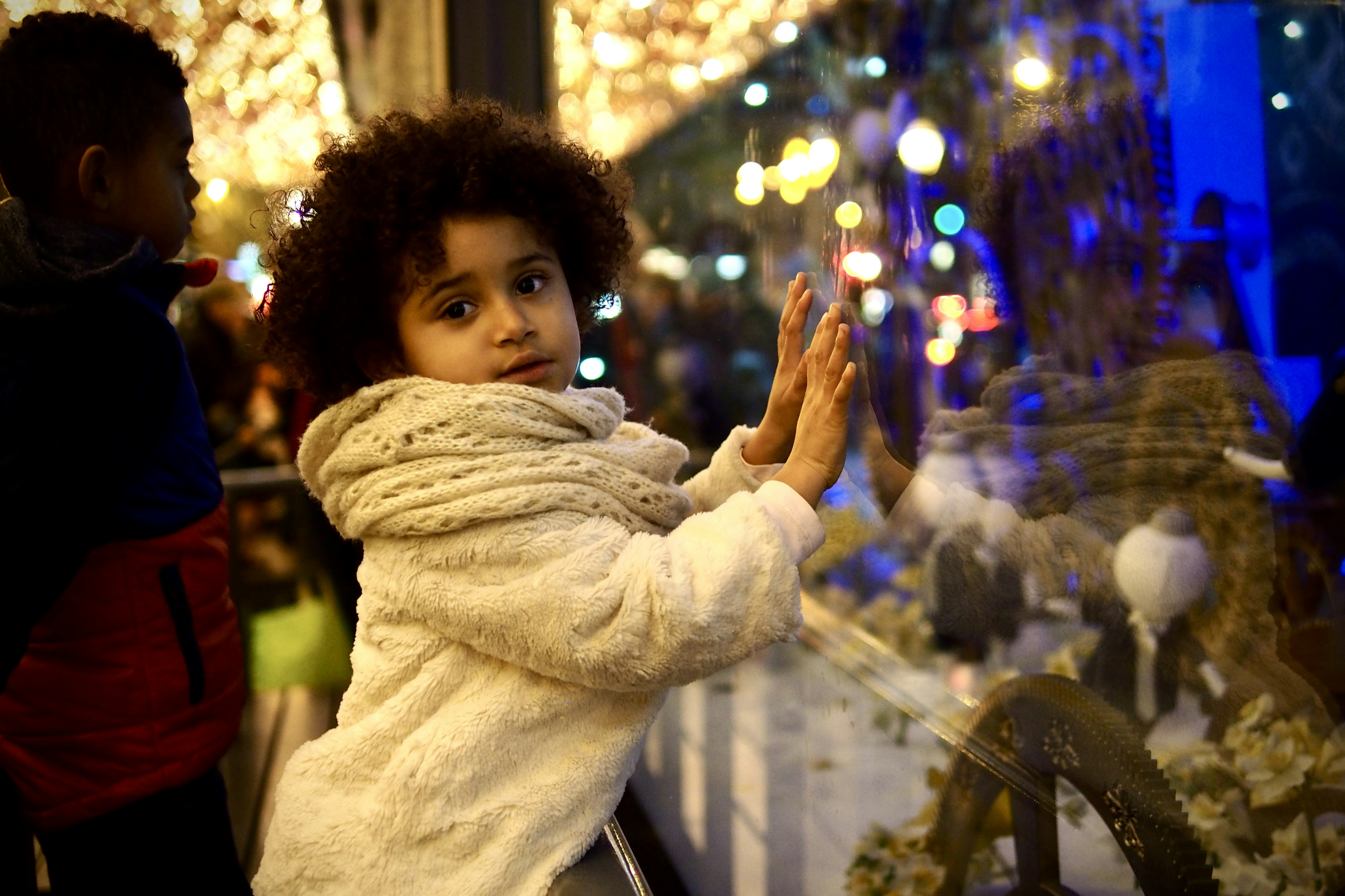 Neon Window Curious: A Girl Reaches Toward Light in Winter Nights