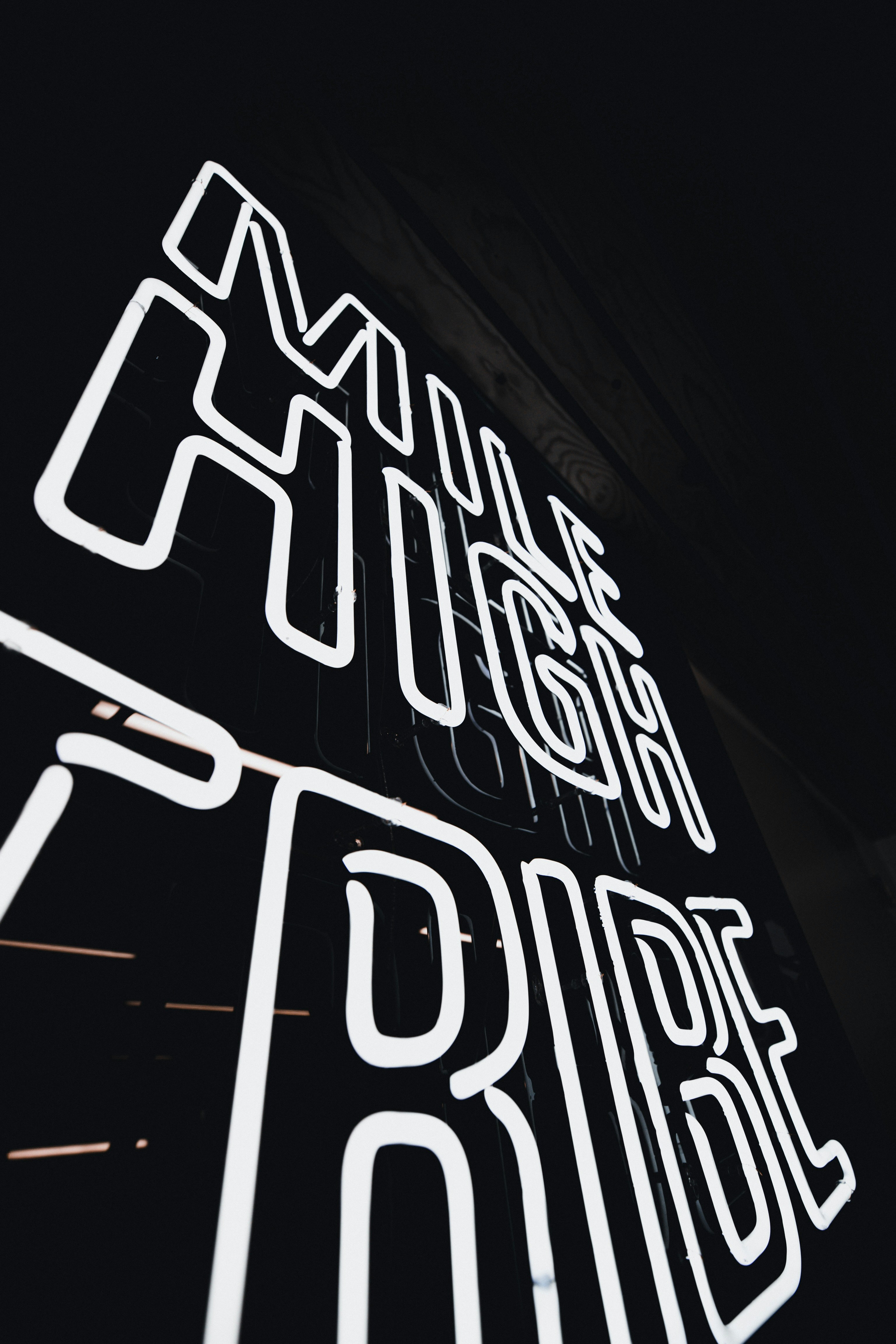 Neon sign displaying the words 'MILE HIGH TRIBE' against a dark background, emphasizing urban culture and community spirit.