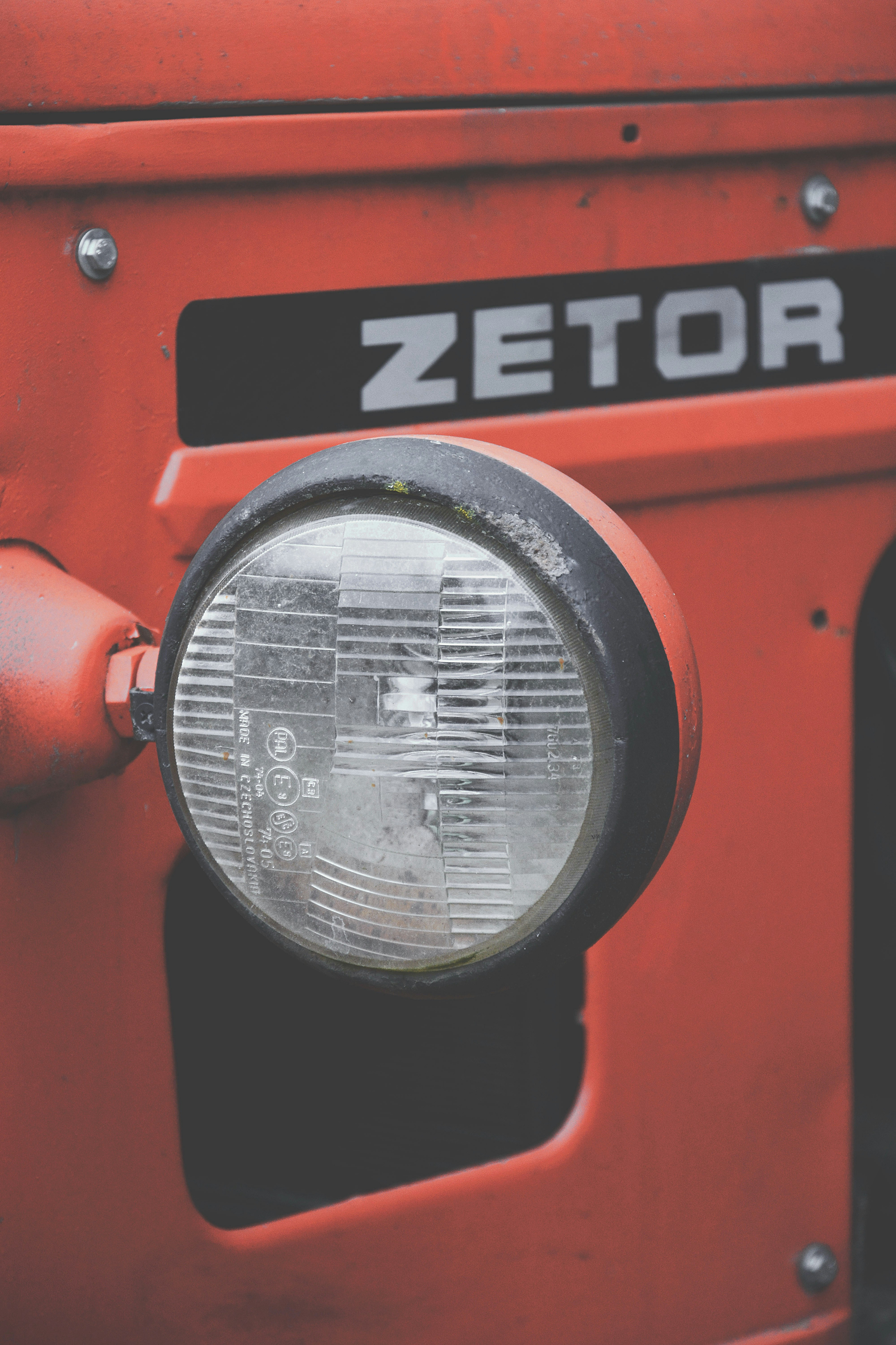 Close-Up of a Red Zetor Headlight: Weathered Farm Machinery in Focus