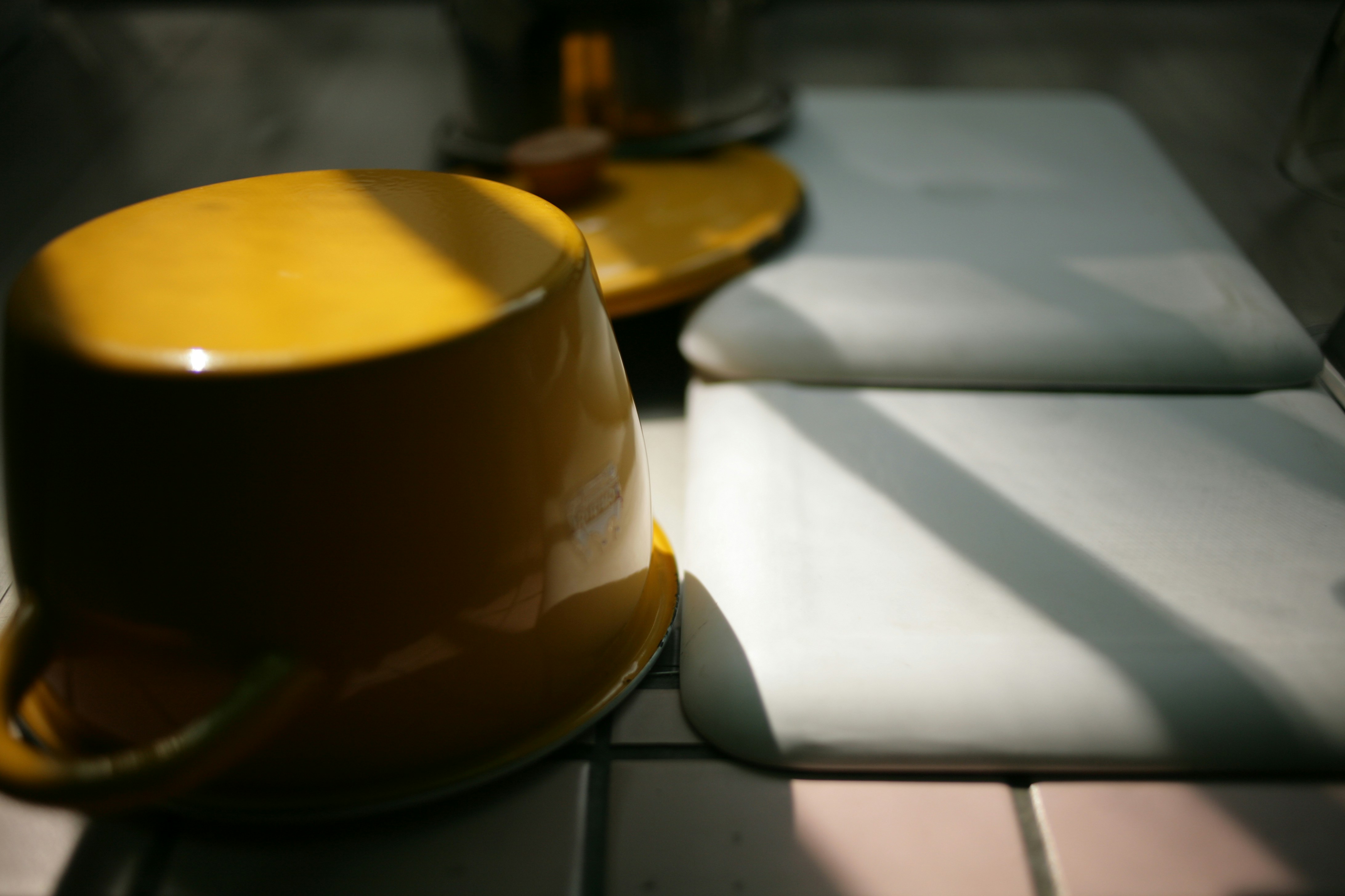 Sunlit Orange Cup Anchored to a Shadowed Counter