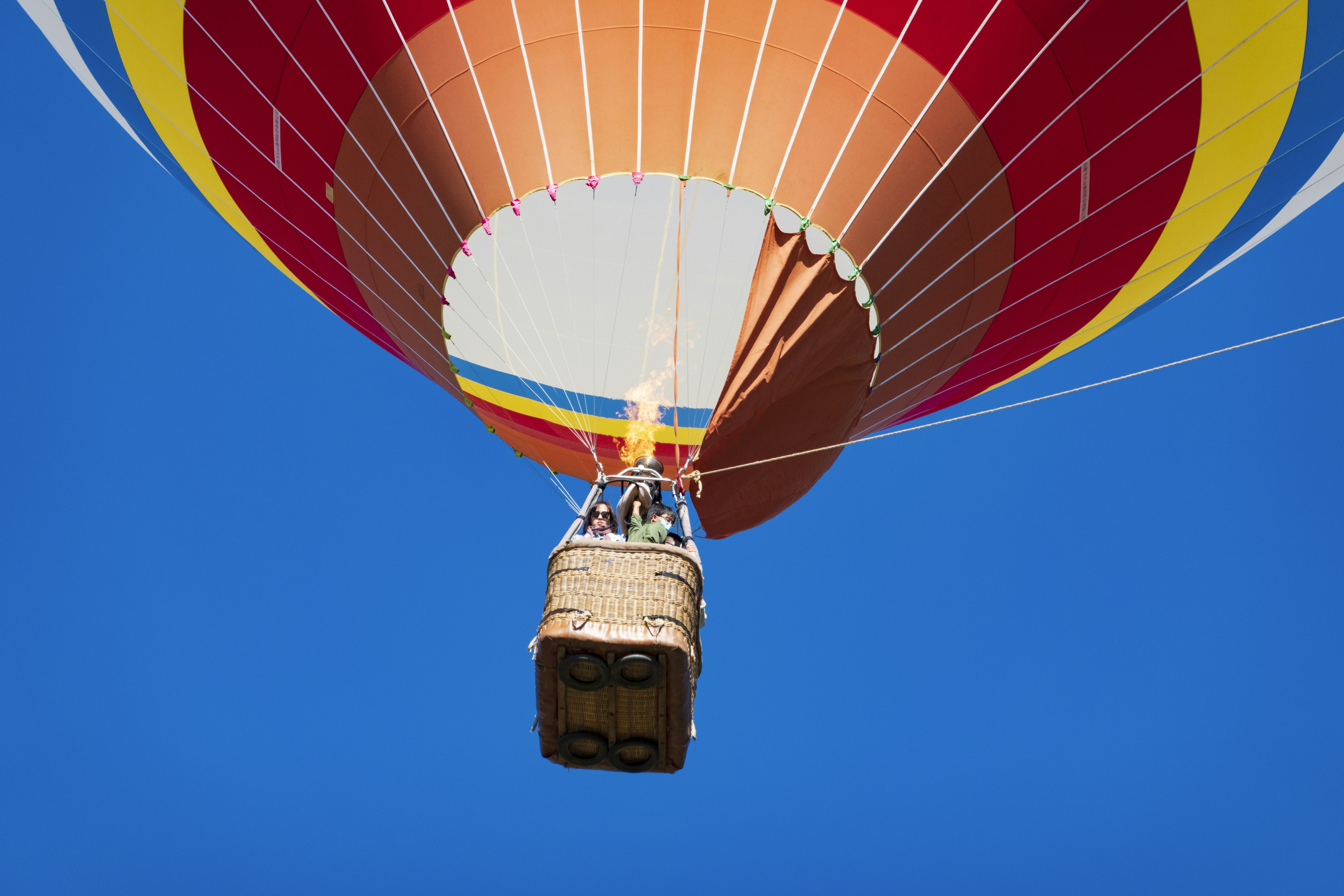 Under a Rainbow of Air: Basket Glide Beneath a Multicolored Balloon