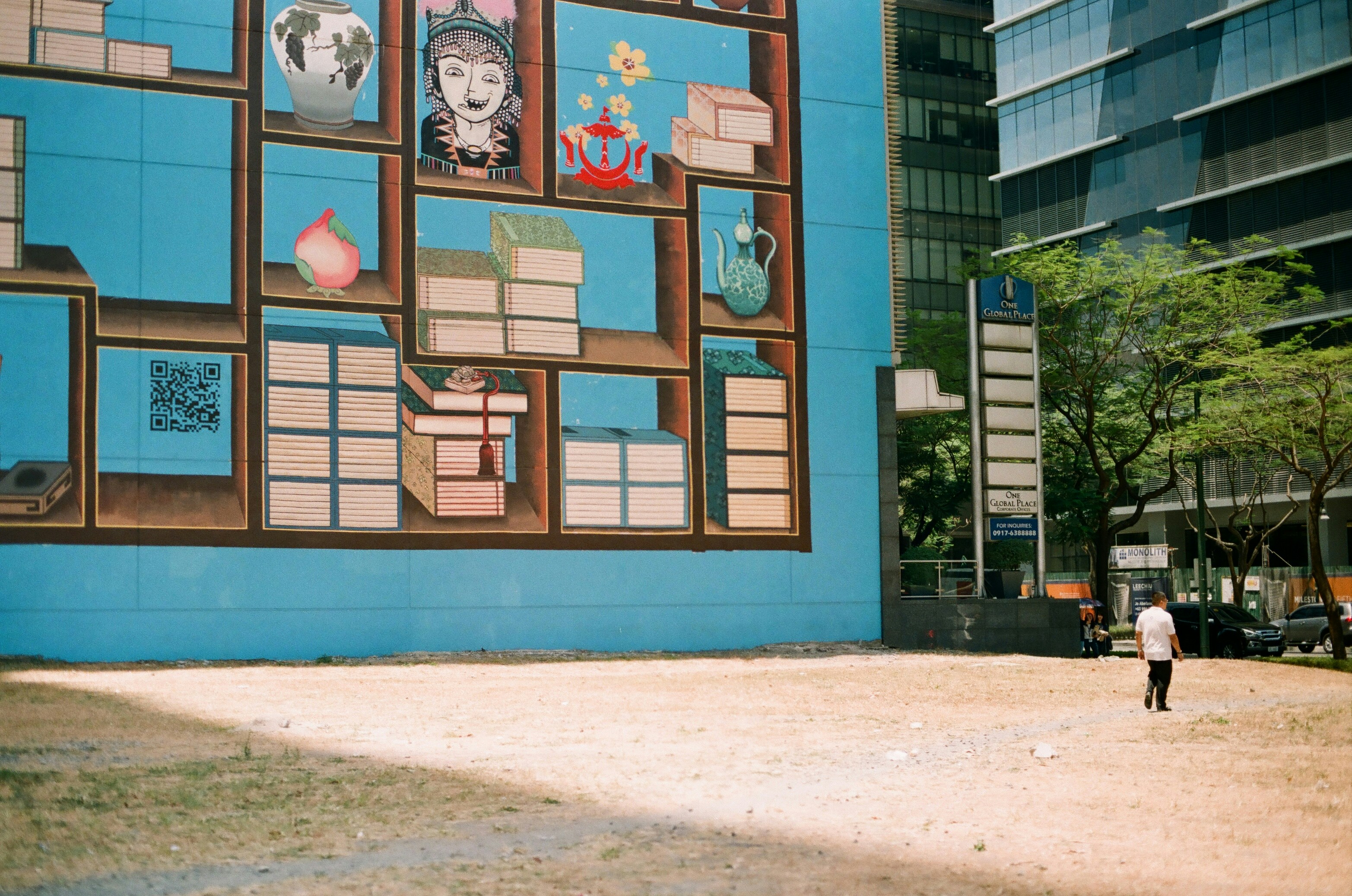 A person walking past a building with a mural on it photo – Free Office ...