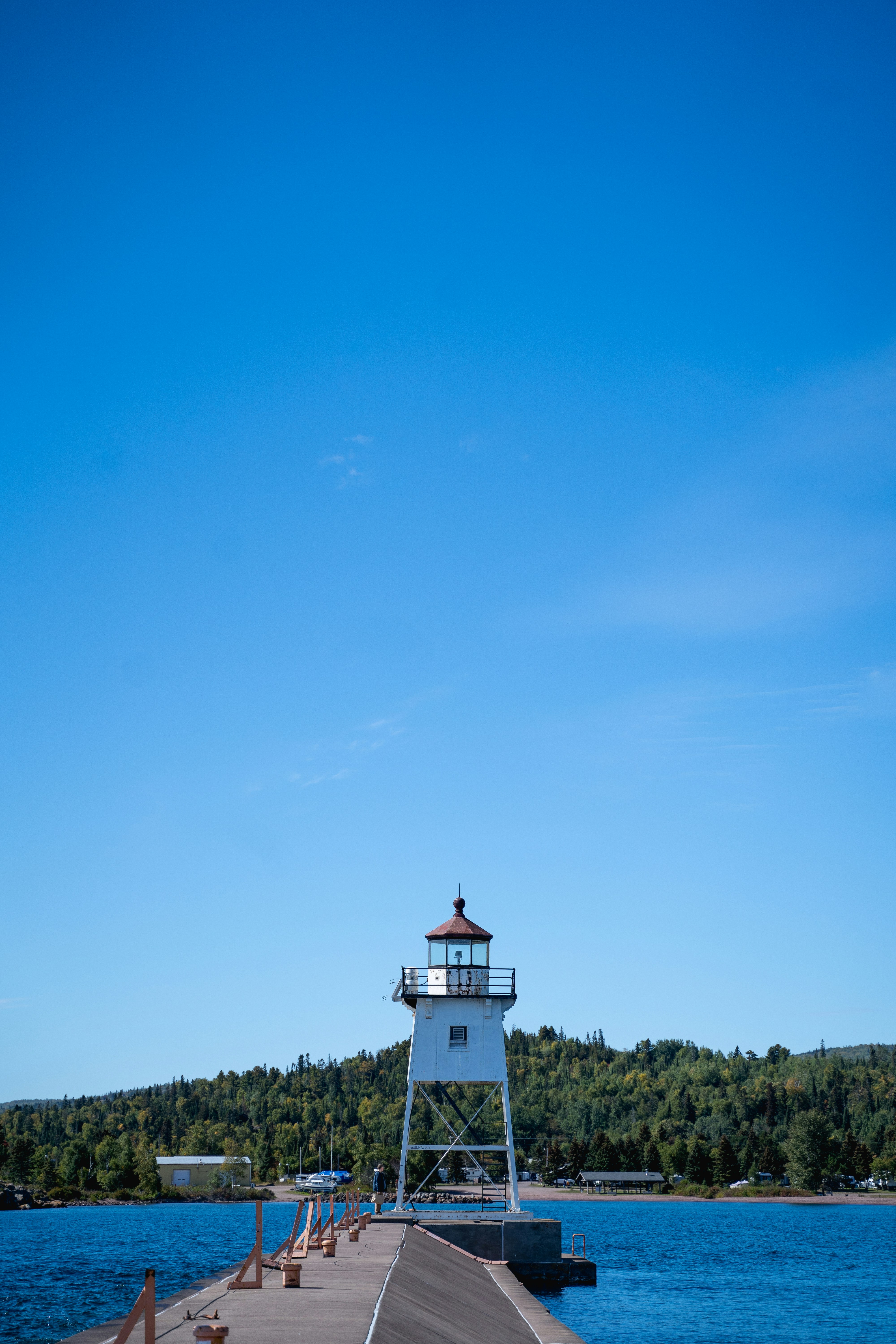 Lighthouse at the Pier's End under a Cerulean Coastal Sky