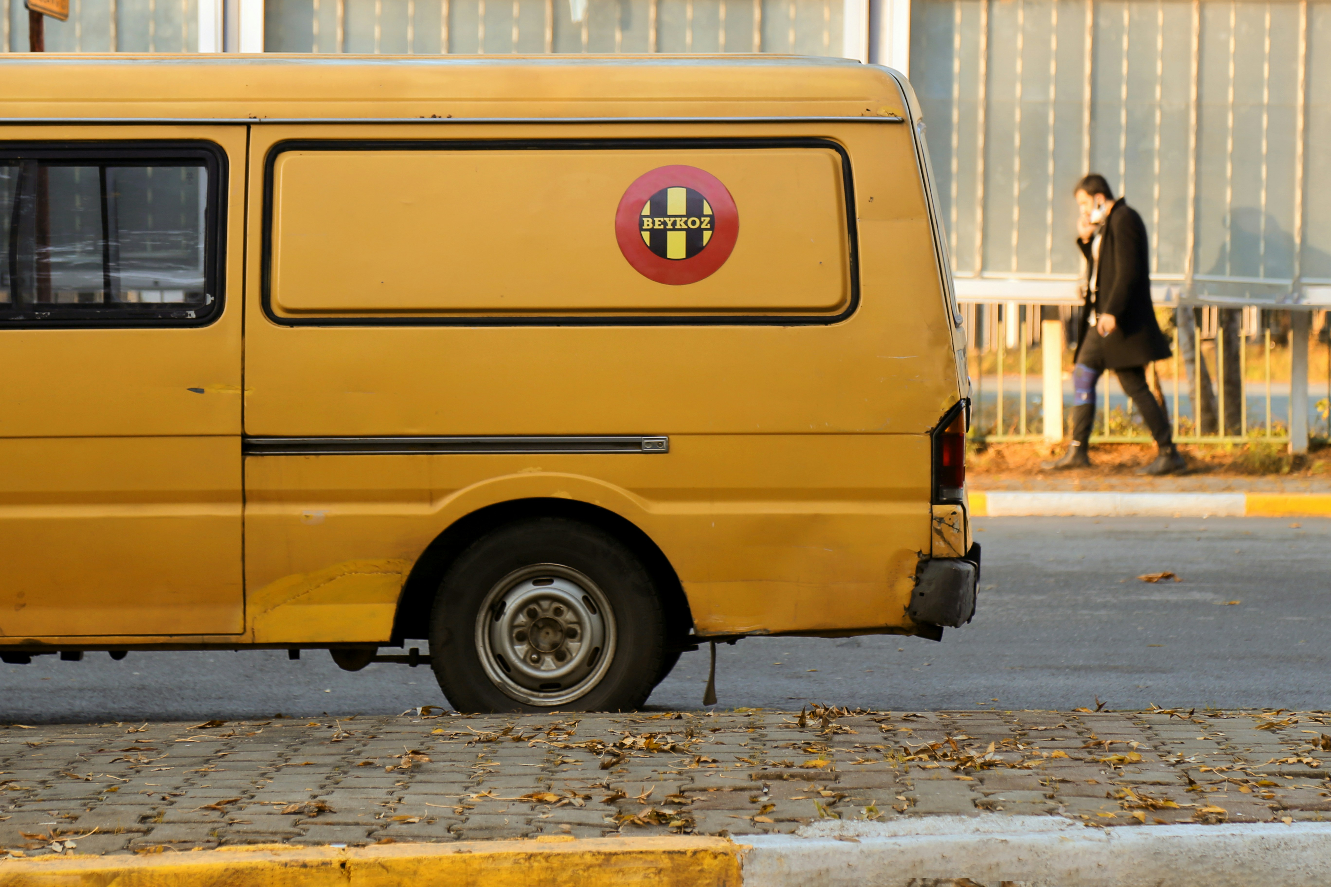Amber Panel Van by the Curb as Distant Pedestrians Pass