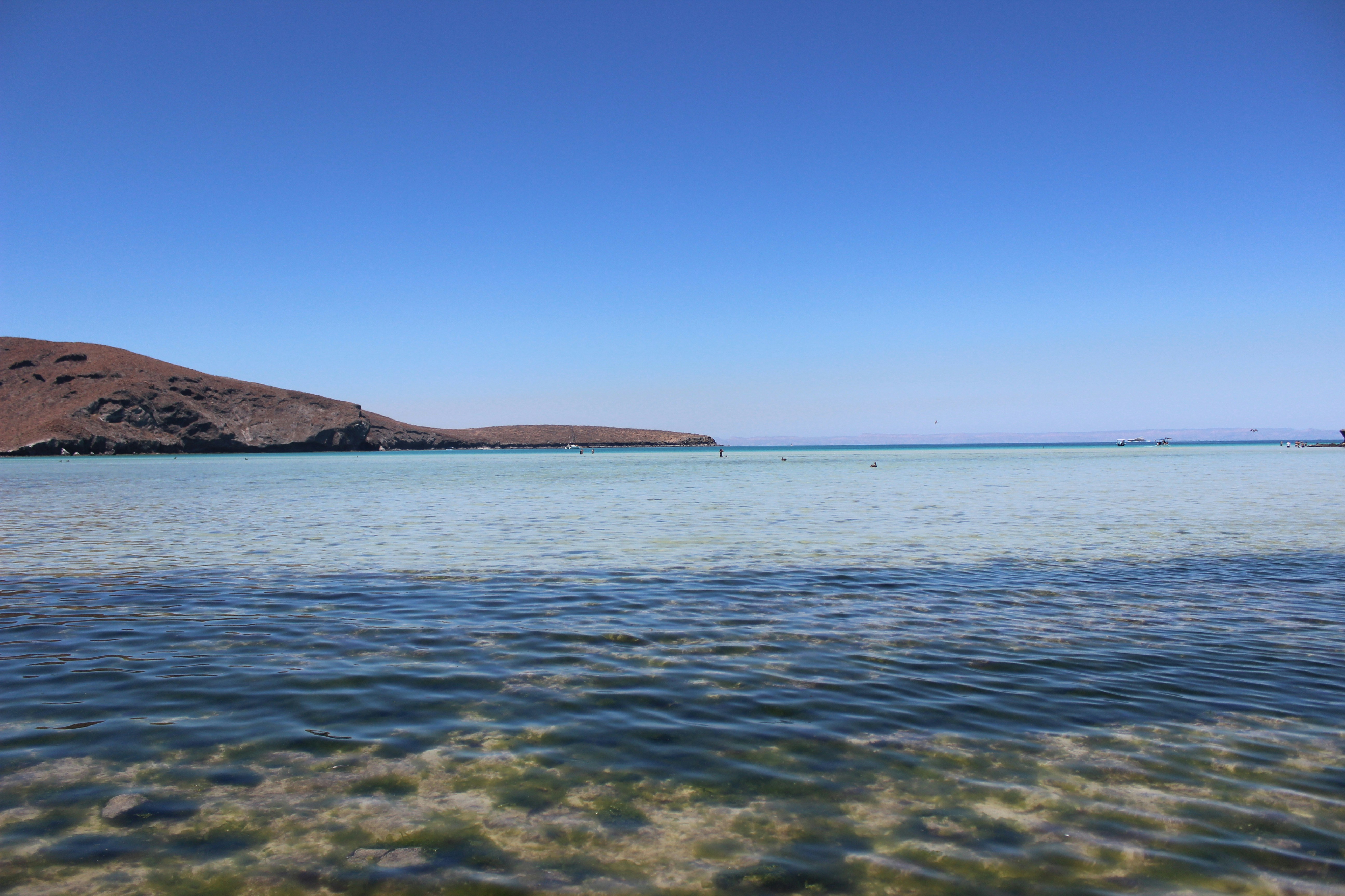 Cerulean Coastline: Crystal Tide Framing a Distant Promontory
