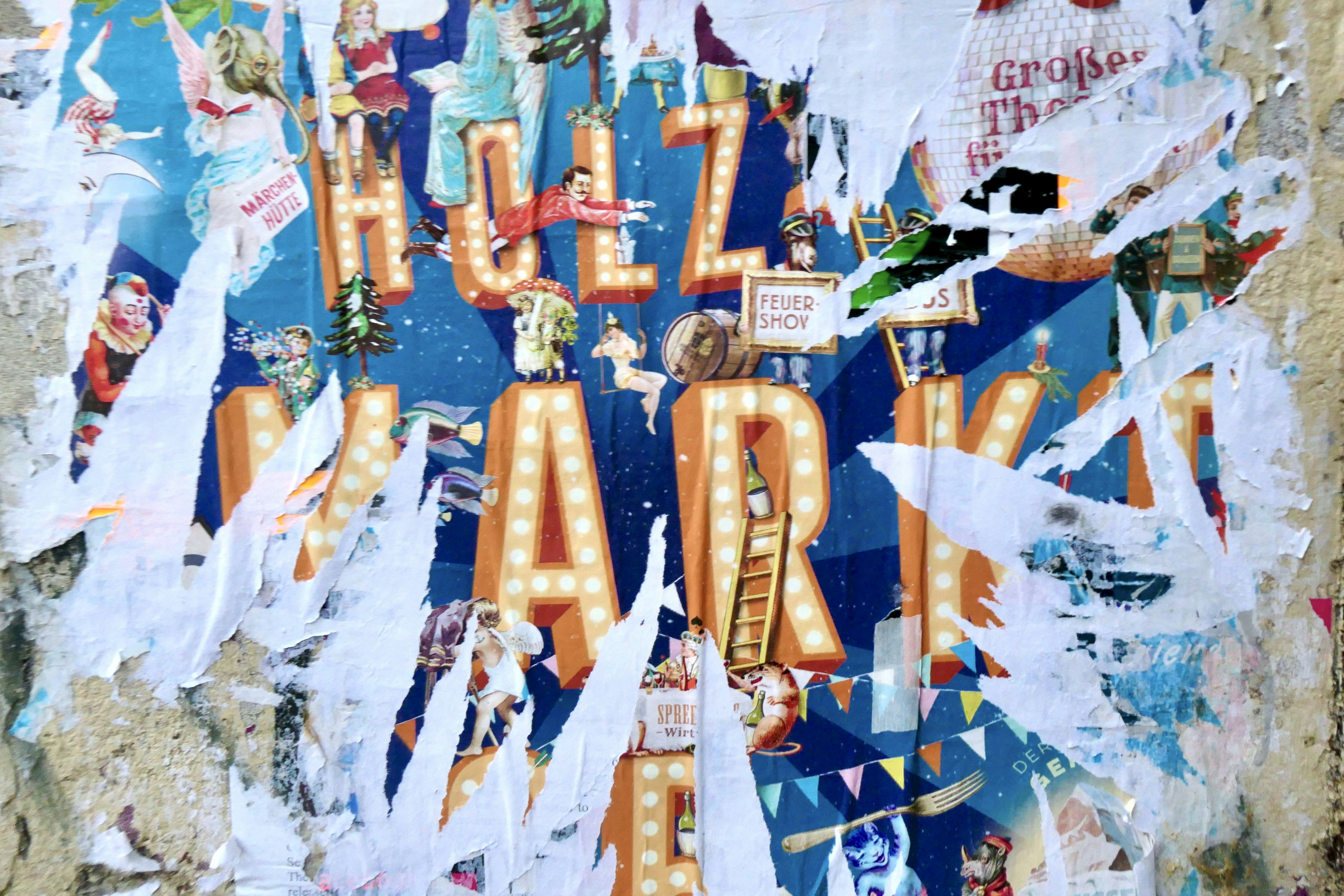 Peeling layers of a vibrant poster reveal the remnants of a festive market, showcasing colorful characters and whimsical designs.