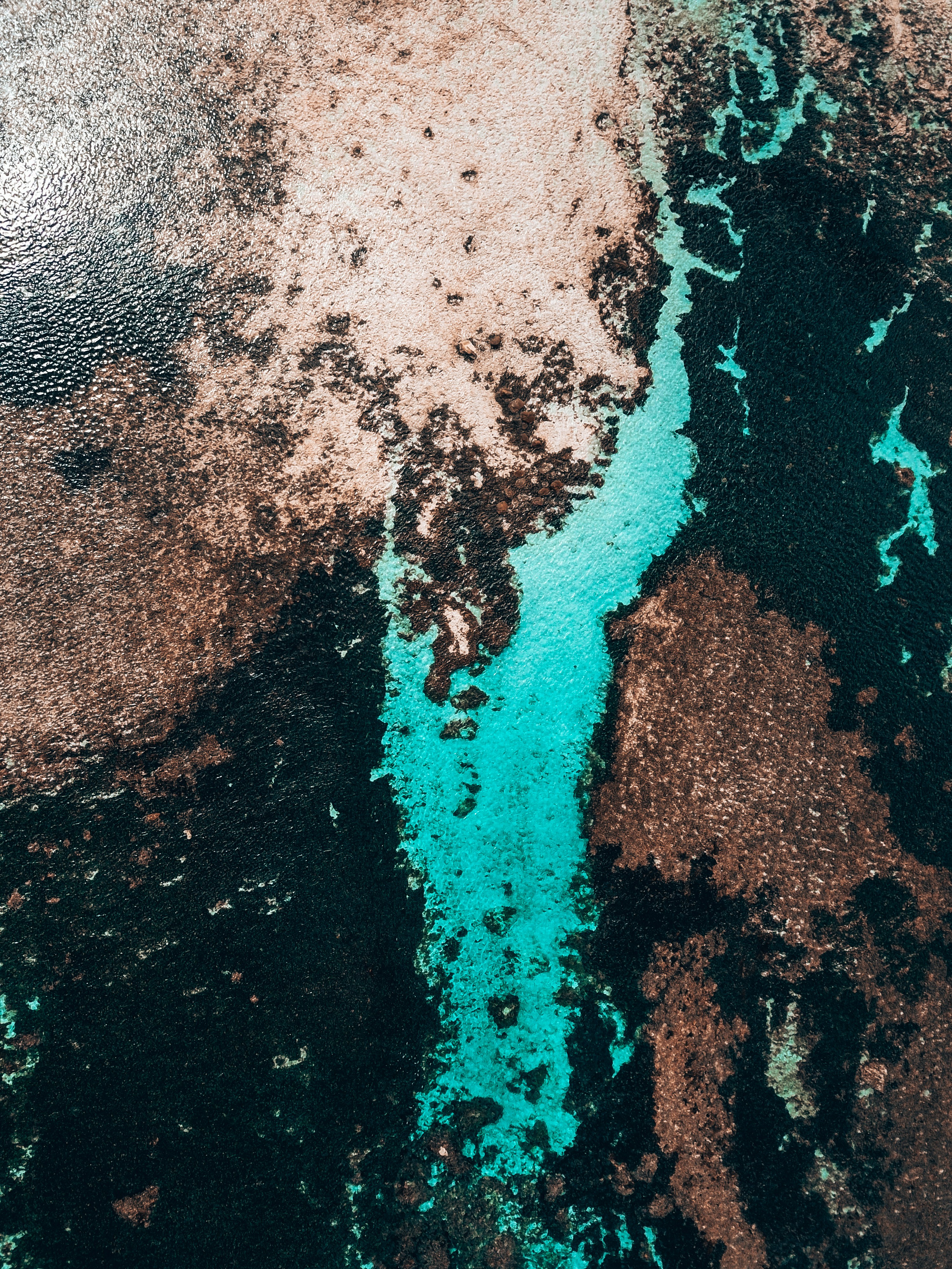 Aerial Veins: Turquoise Stream Carving Through Rust and Night