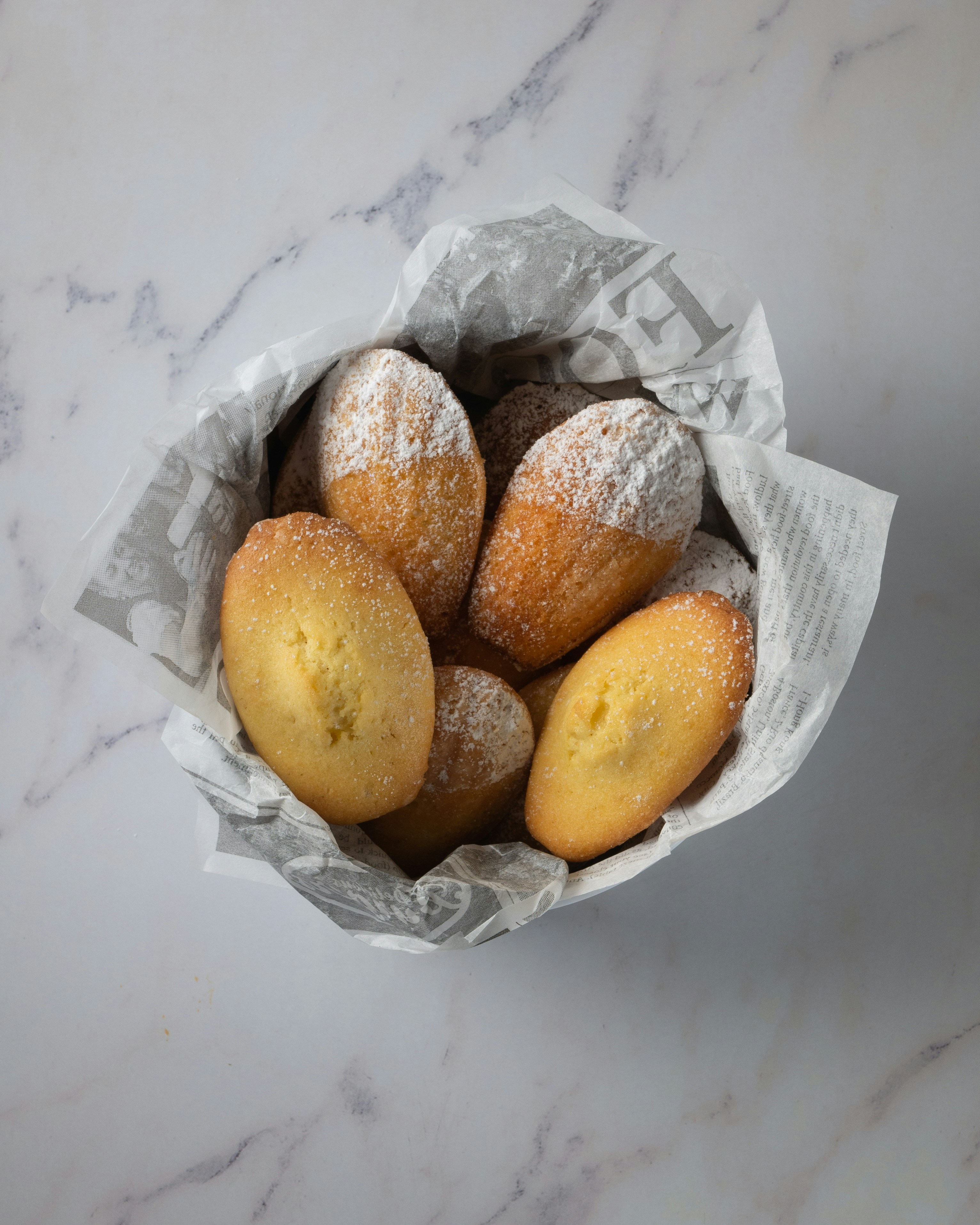 Powdered Happiness: Crescent Pastries Nestled in Newspaper