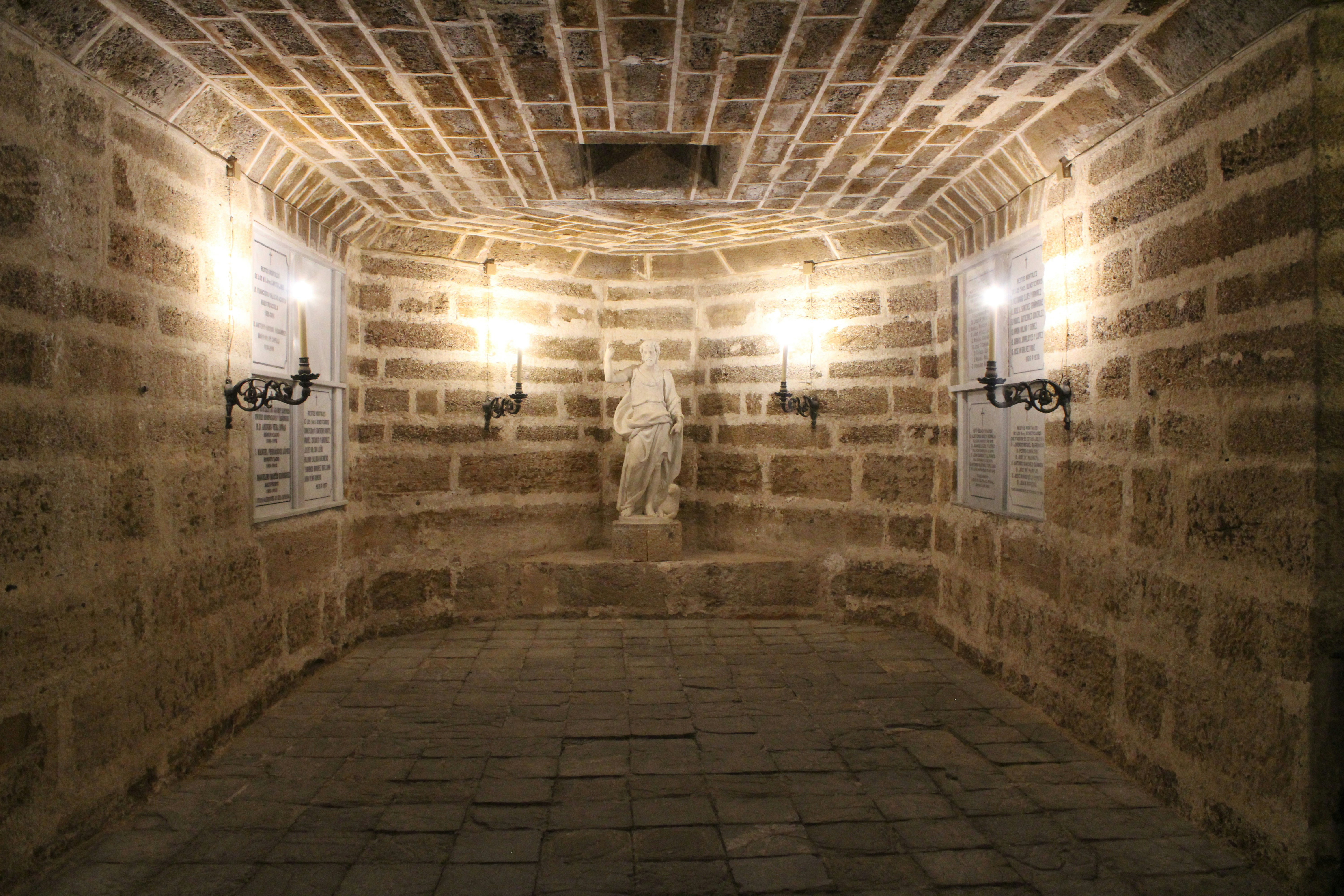gray concrete statue in a brick tunnel