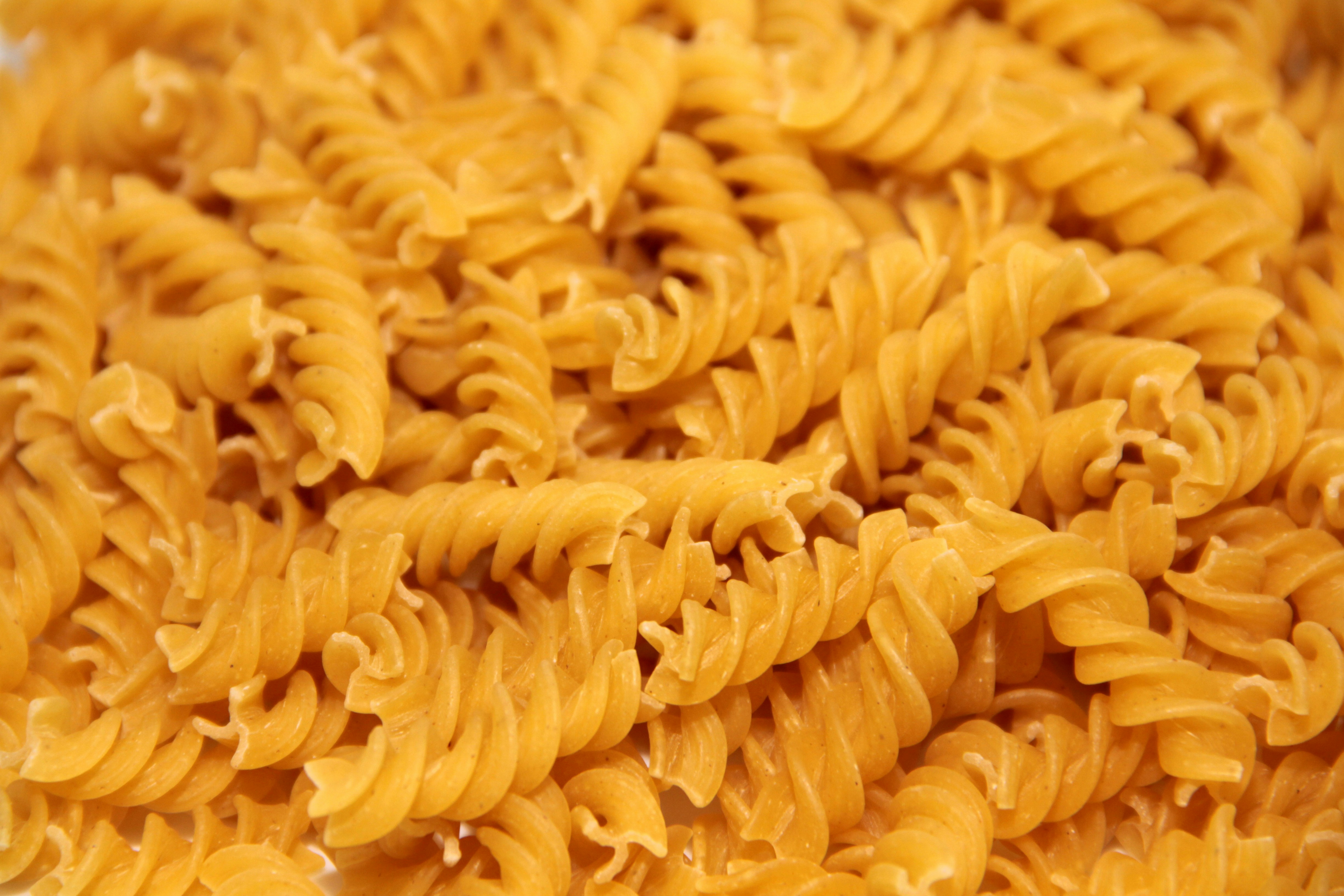 Close-up of uncooked fusilli pasta showcasing its spiral shape and golden hue.
