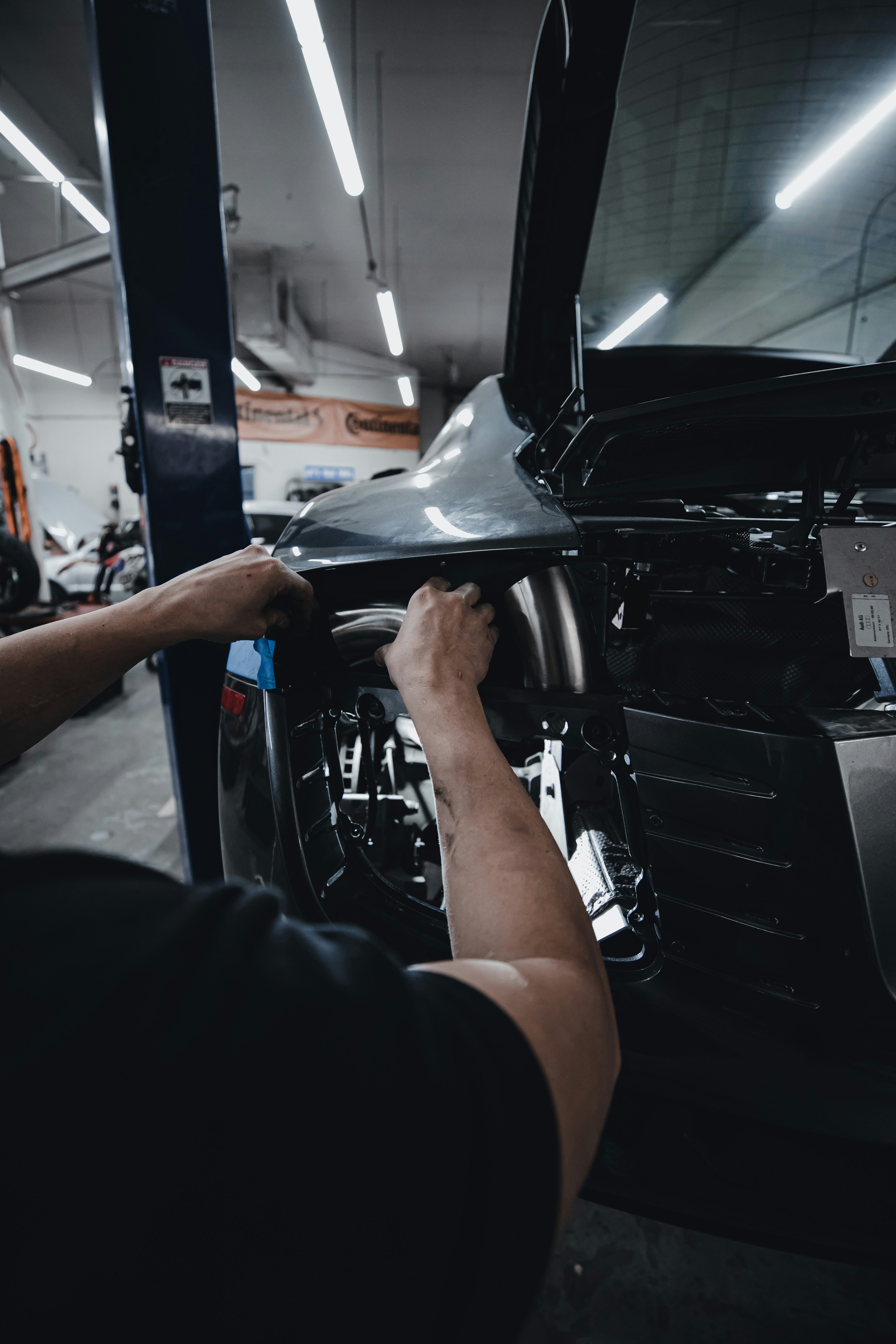 Hands at Work: Car Restoration in a Neon-lit Workshop