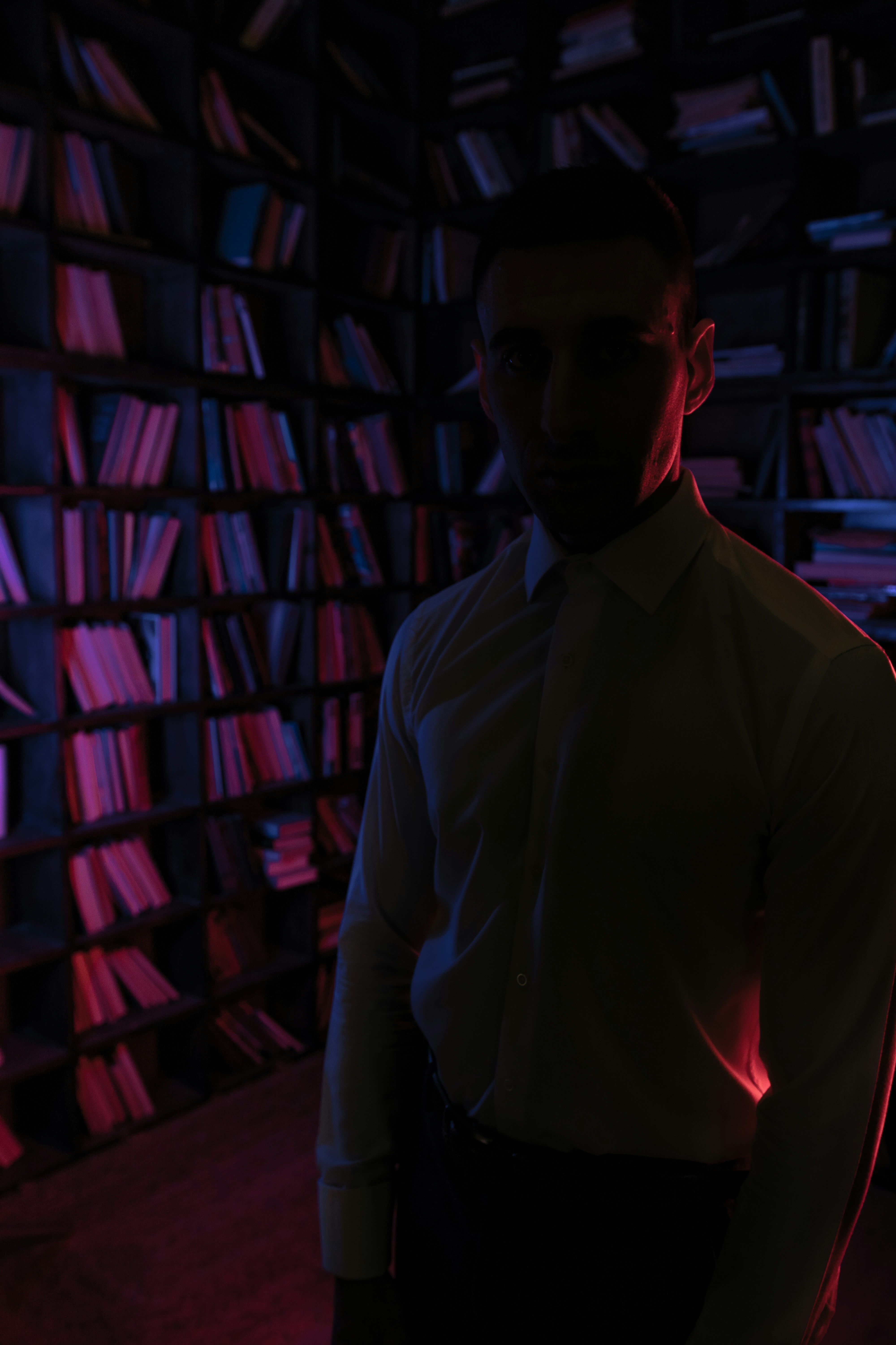 Shadowed Scholar in a Room of Quiet Stacks
