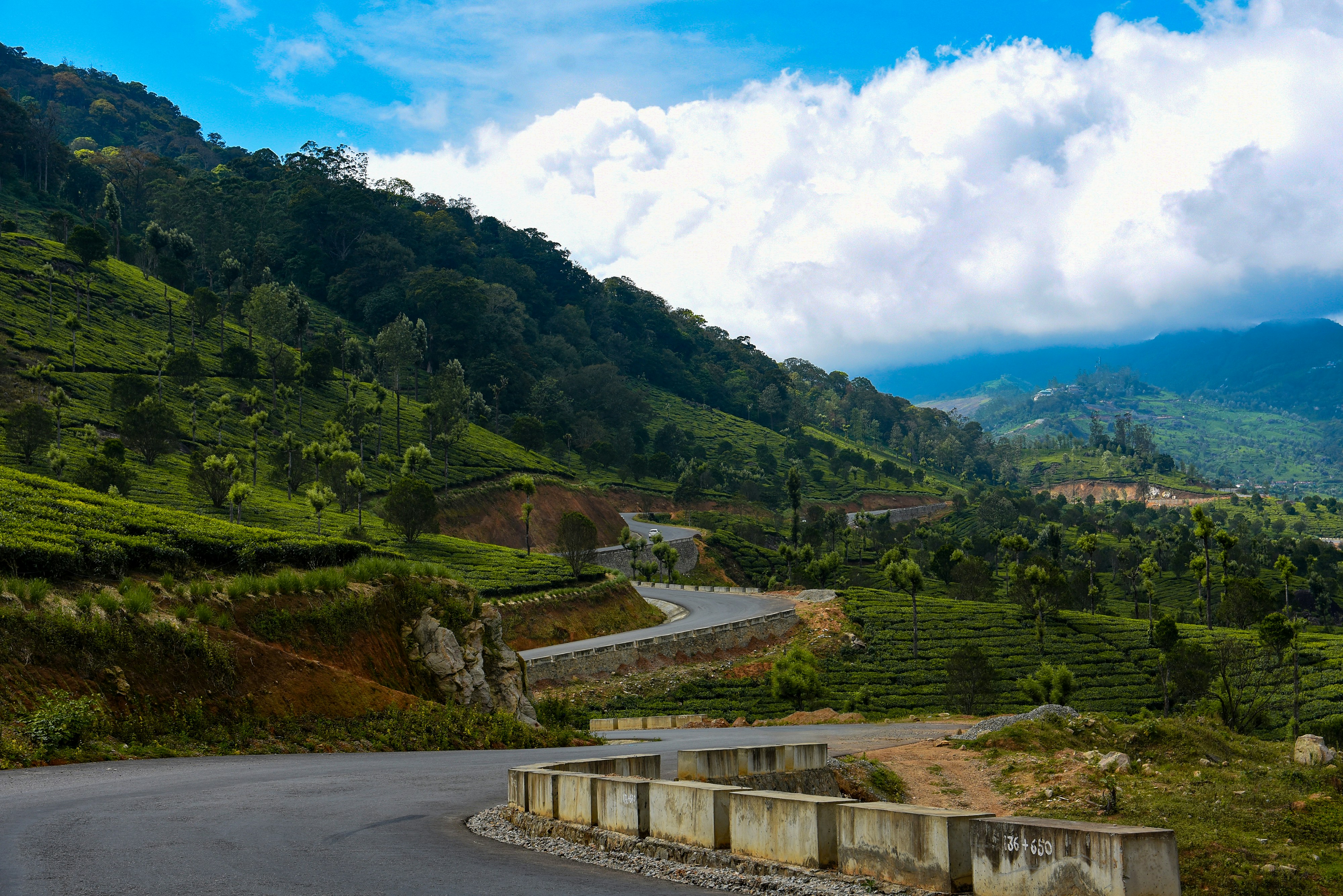 Serpentine Road Through Terraced Green Hills Beneath a Cloudy Sky