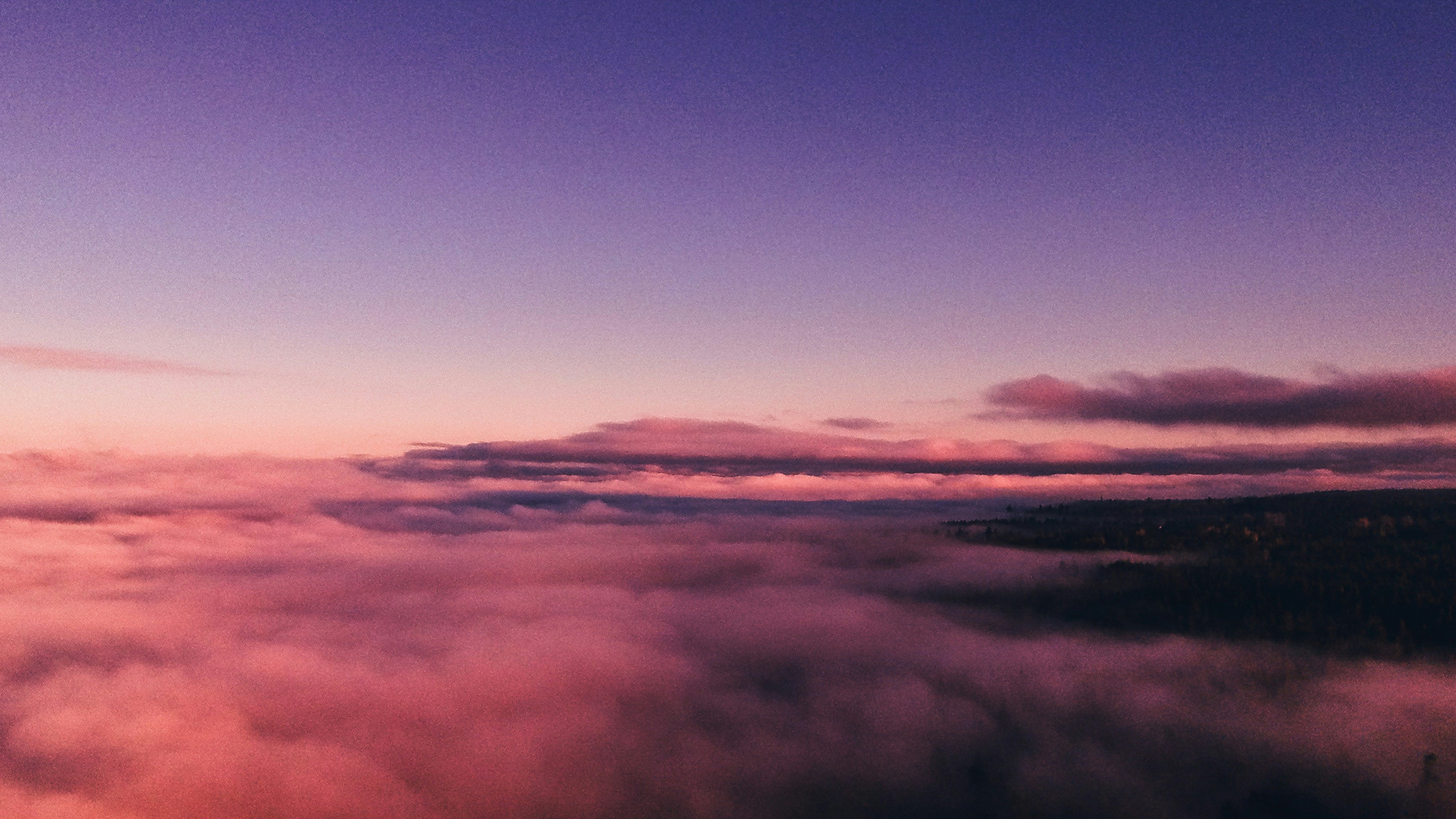 Soft, pastel clouds blanket the horizon under a twilight sky, creating a serene atmosphere. The scene captures the tranquil beauty of nature at dusk.