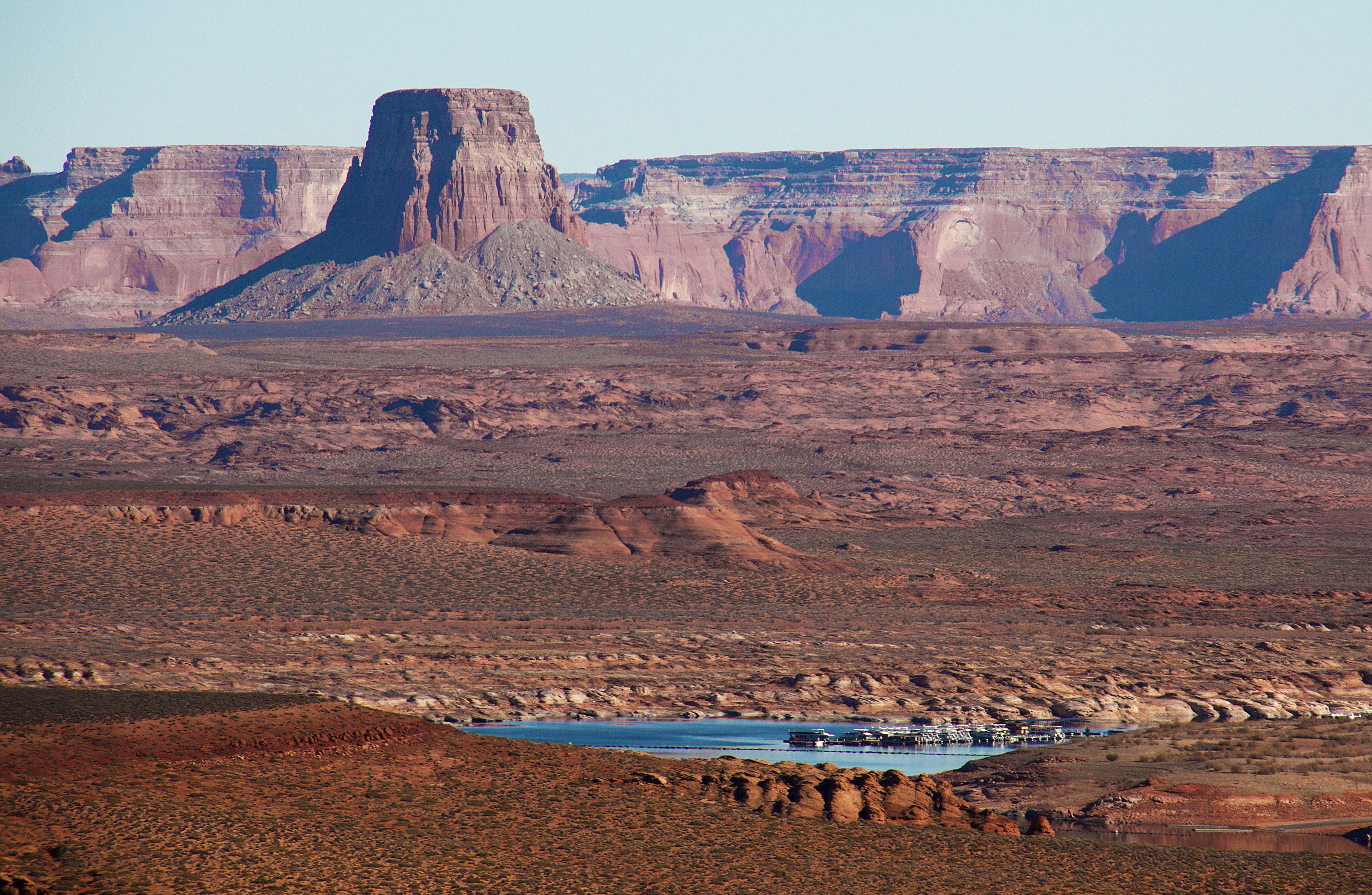 Distant mesa under a clear sky with a small blue water body nestled in the arid landscape.