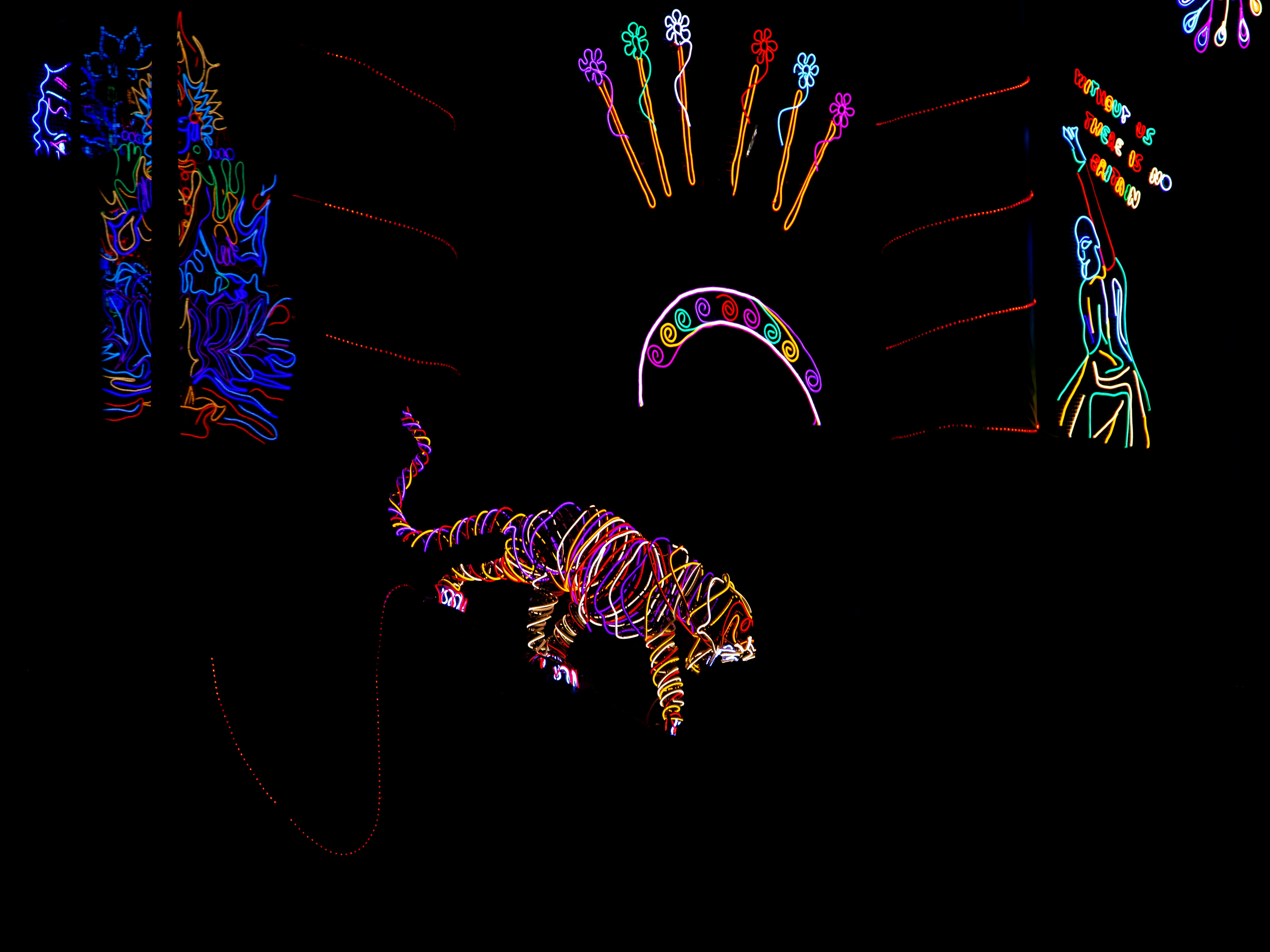 Vibrant neon tiger leaping amidst a backdrop of colorful light patterns and abstract shapes, creating a dynamic visual experience.