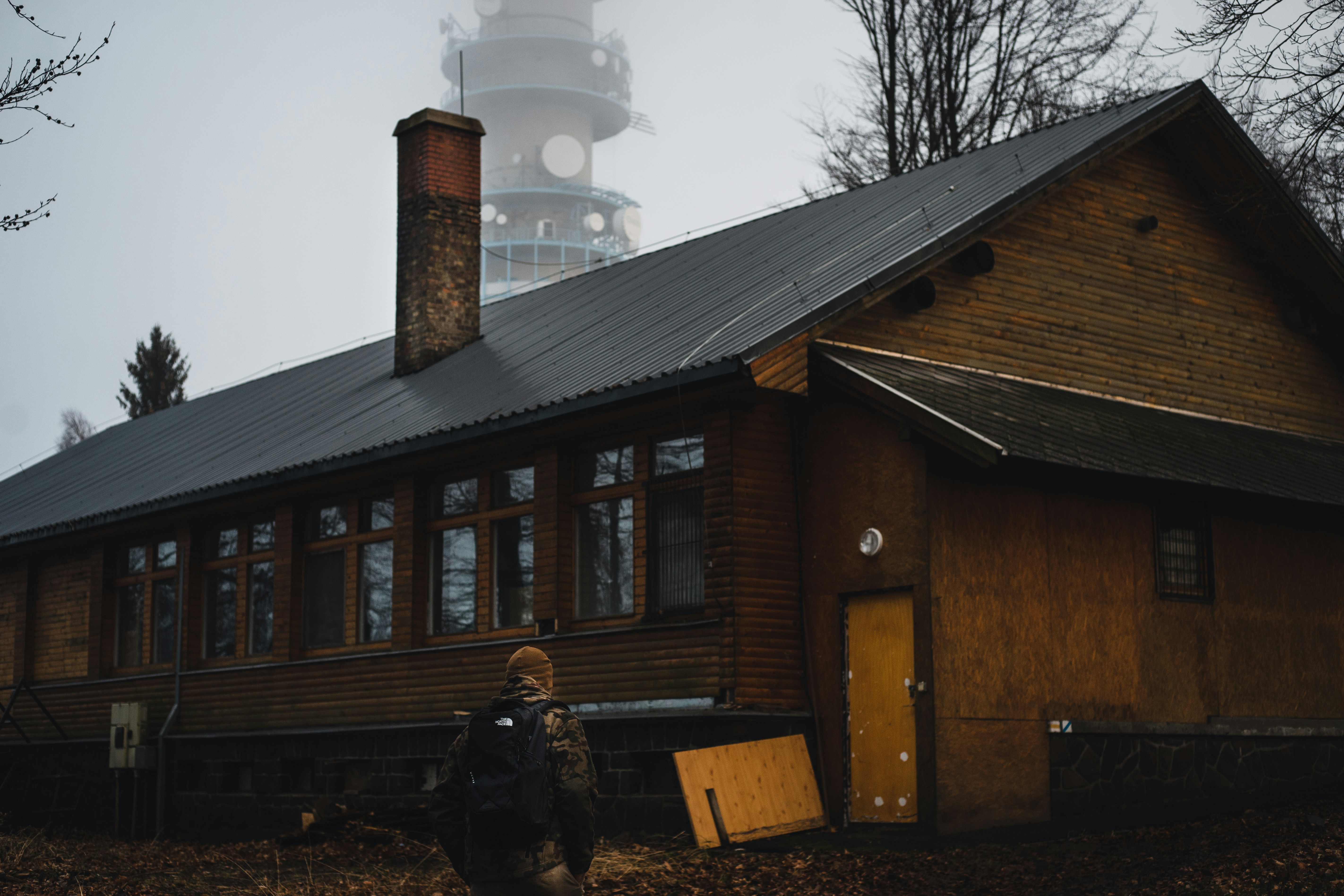 Forest Ranger at Dusk: The Wooden Lodge Beneath a Misty Tower