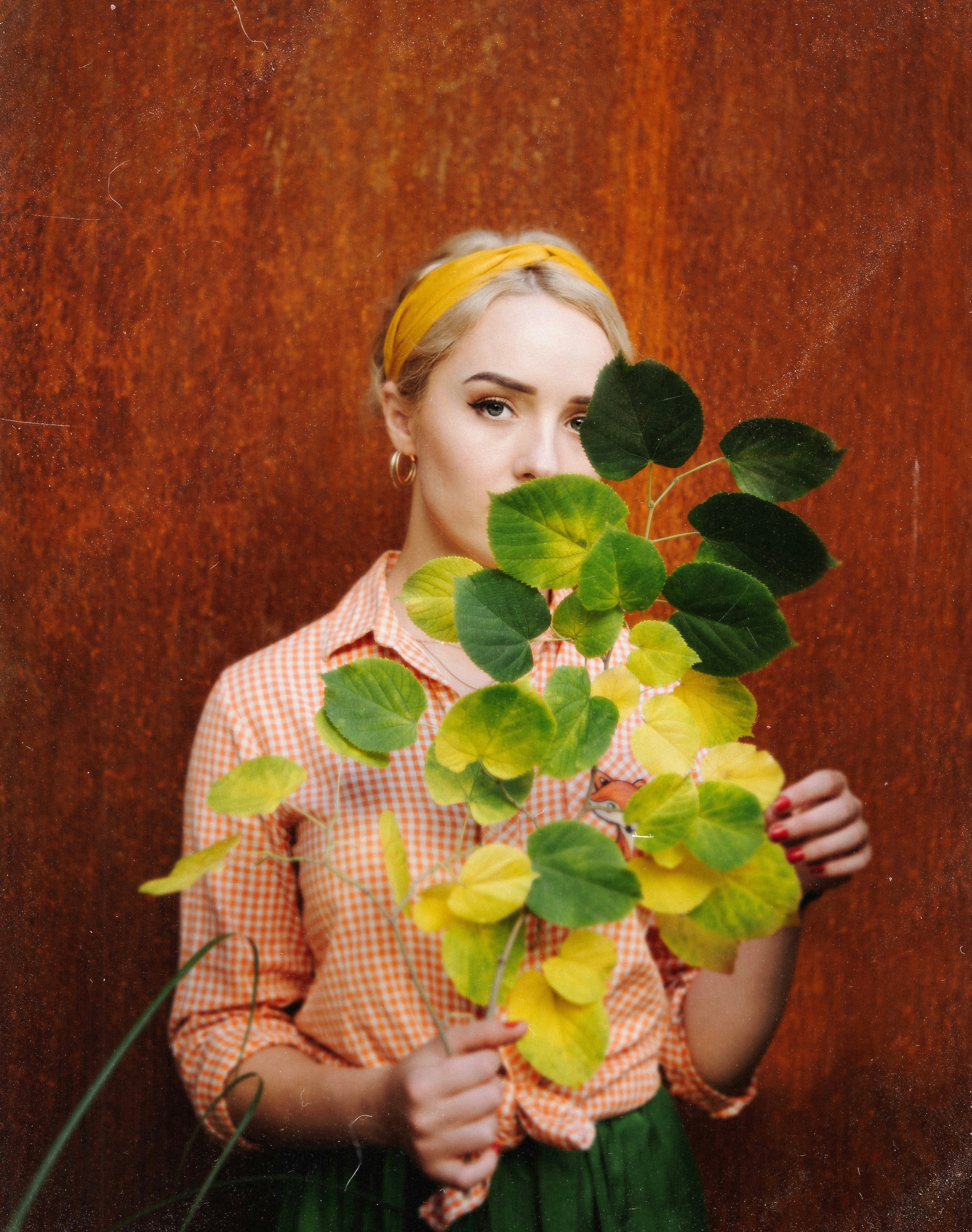 Leaves as Veil: A Portrait Against a Rusted Canvas