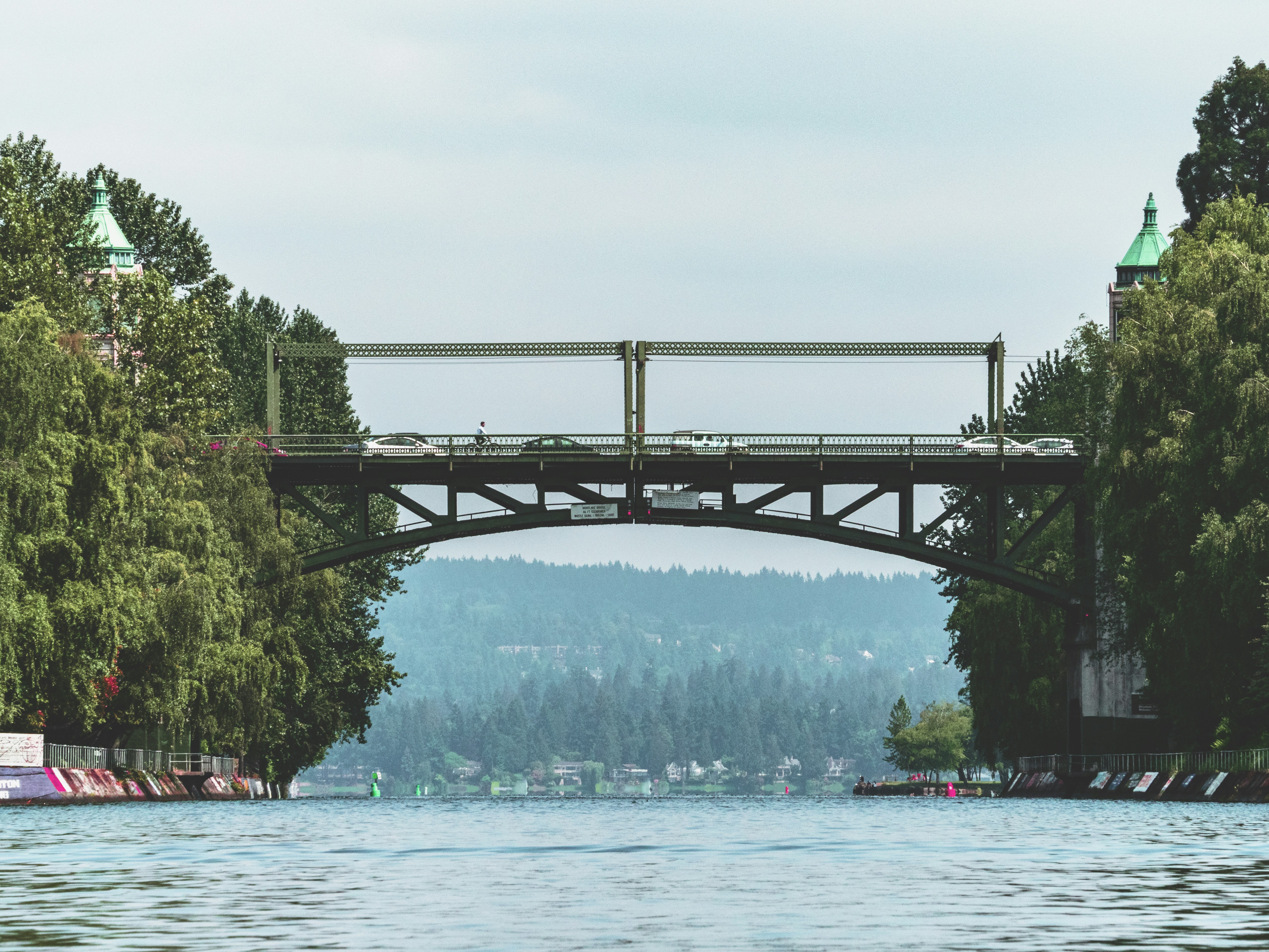 Steel Arch Over a Quiet River, Framed by Emerald Canopies