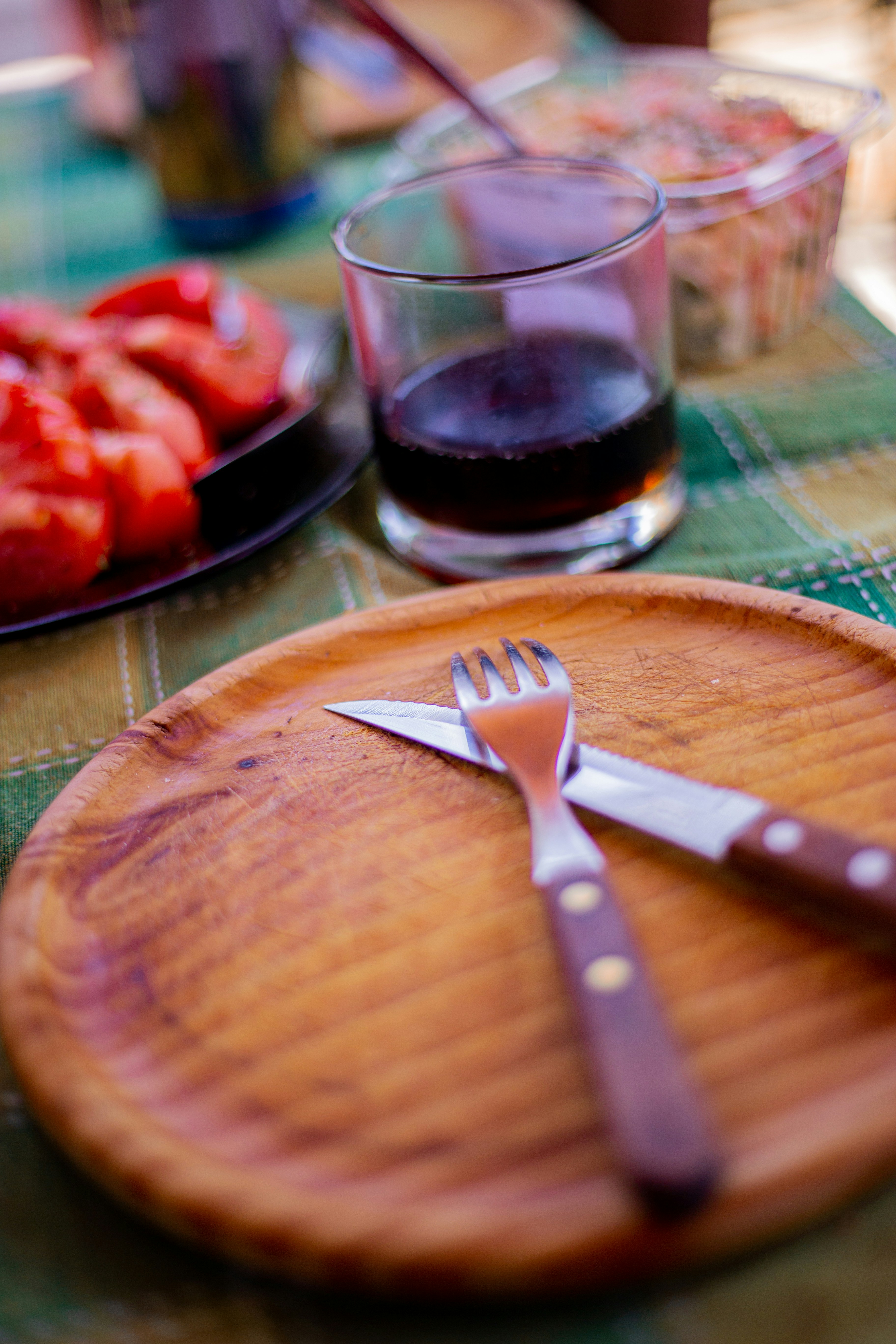 Wooden Plate and Utensils in Blur-Lit Table Setting