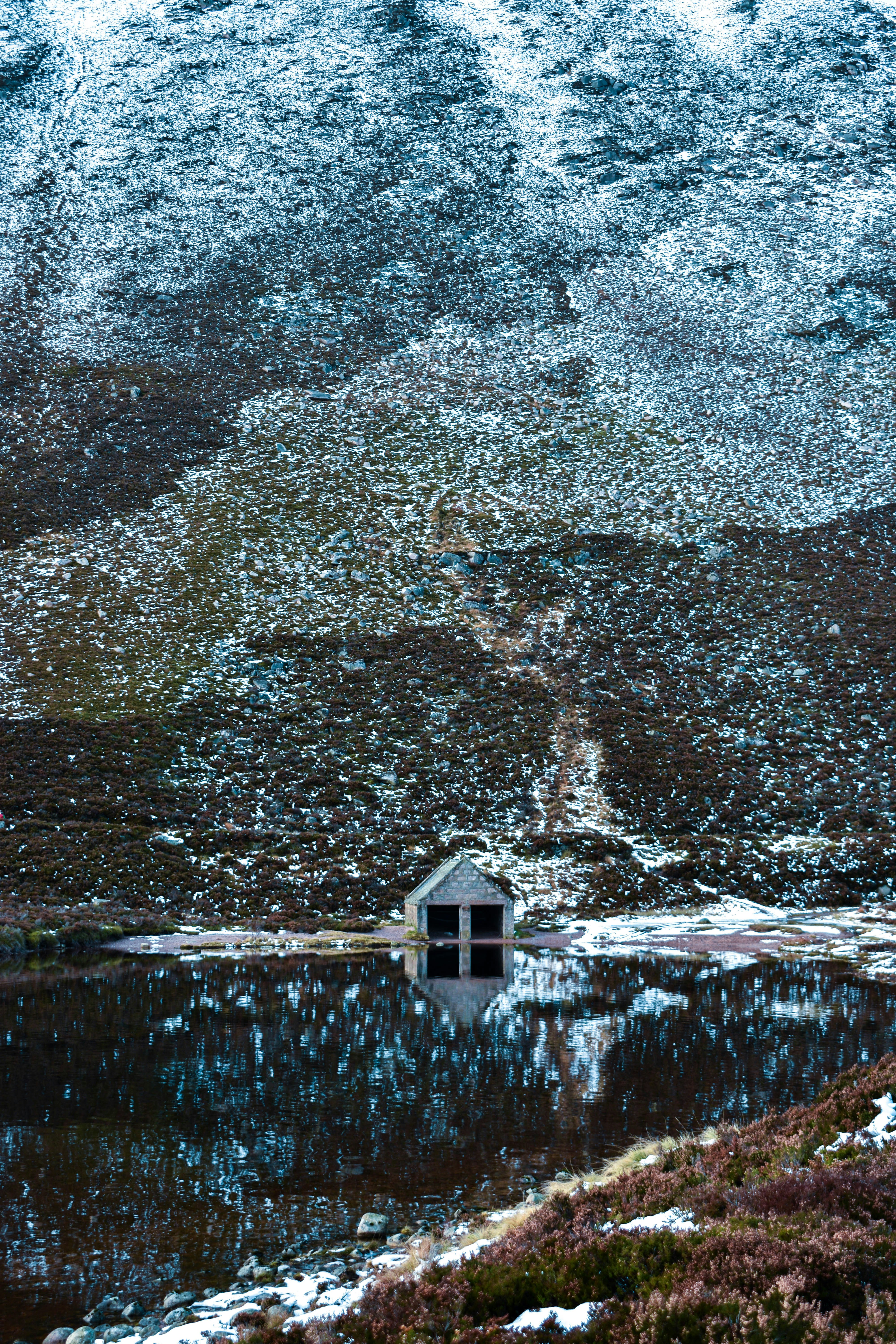 Hut on a Mirror Lake Beneath a Snow-Kissed Ridge
