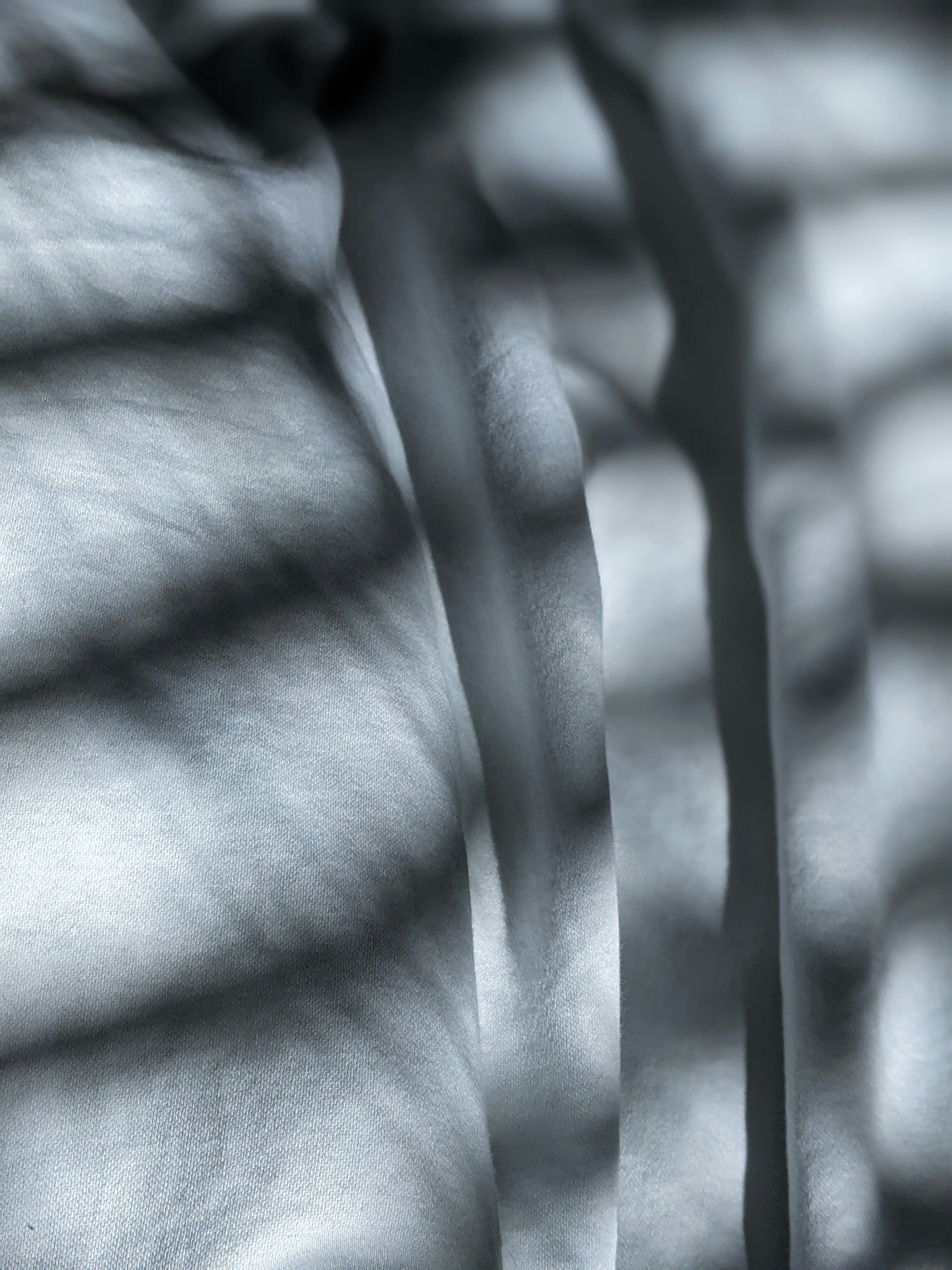 Soft fabric illuminated by natural light, creating a play of shadows and highlights that evoke a sense of tranquility.