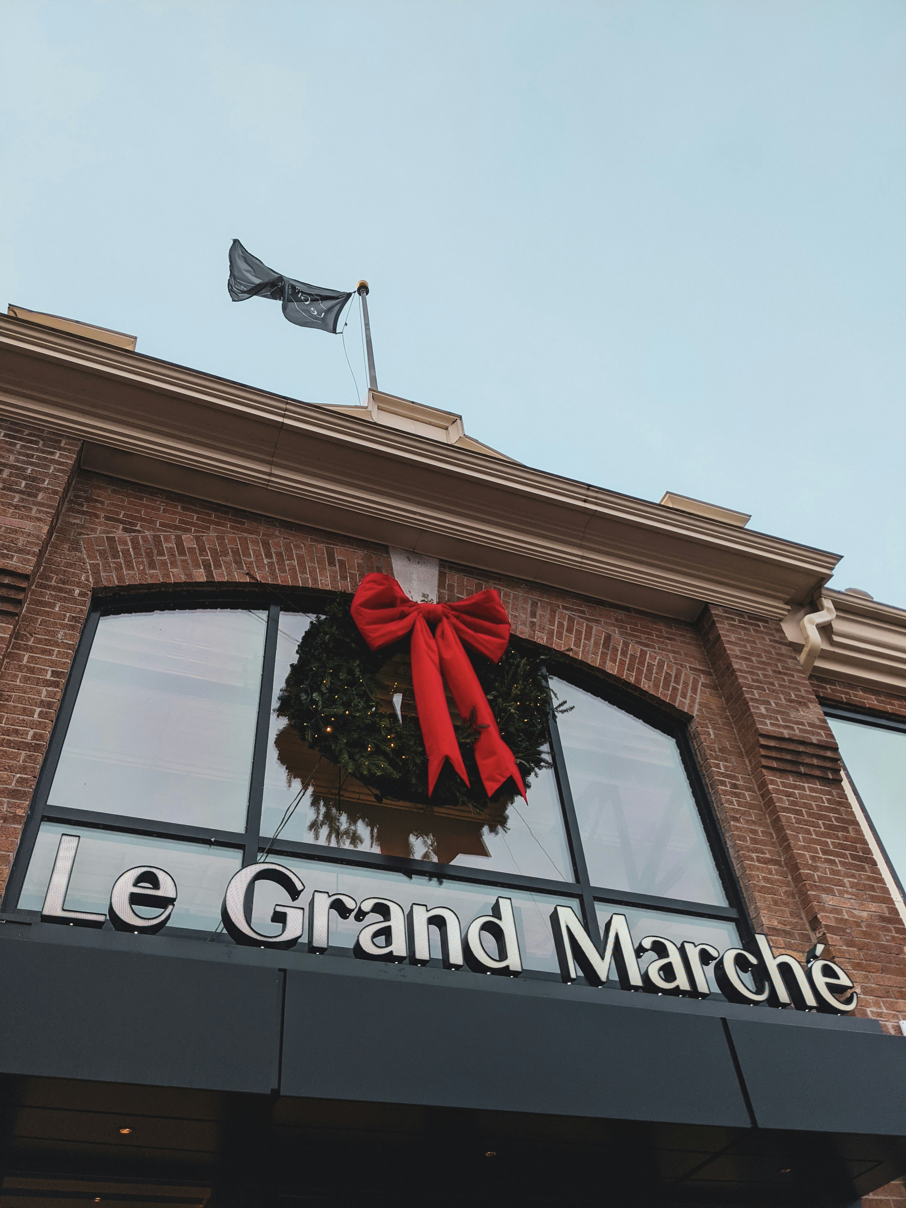 Holiday Wreath Framed by Brick Archway Above Le Grand Marché