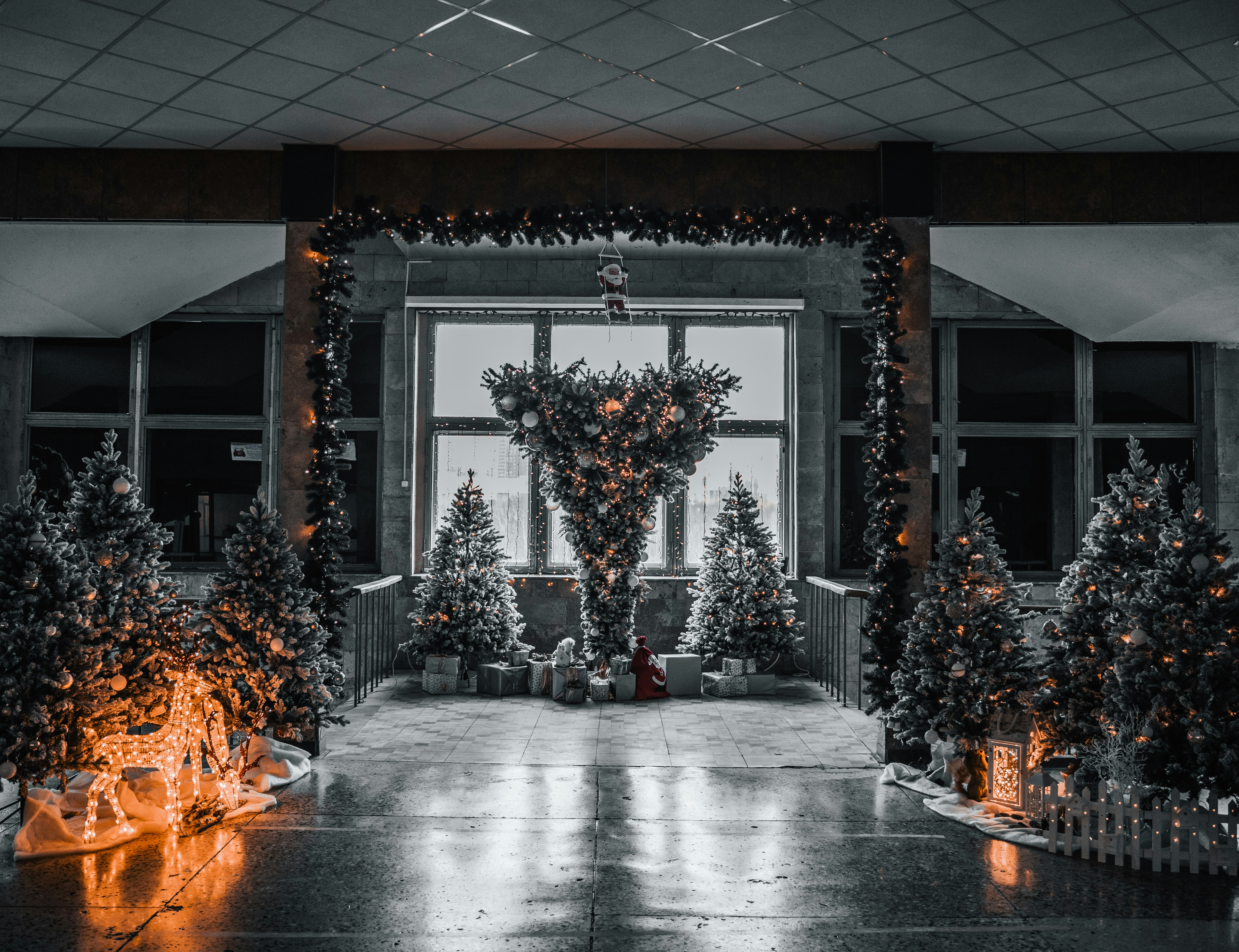 Festive windowscape: a candlelit winter display framed by garlands