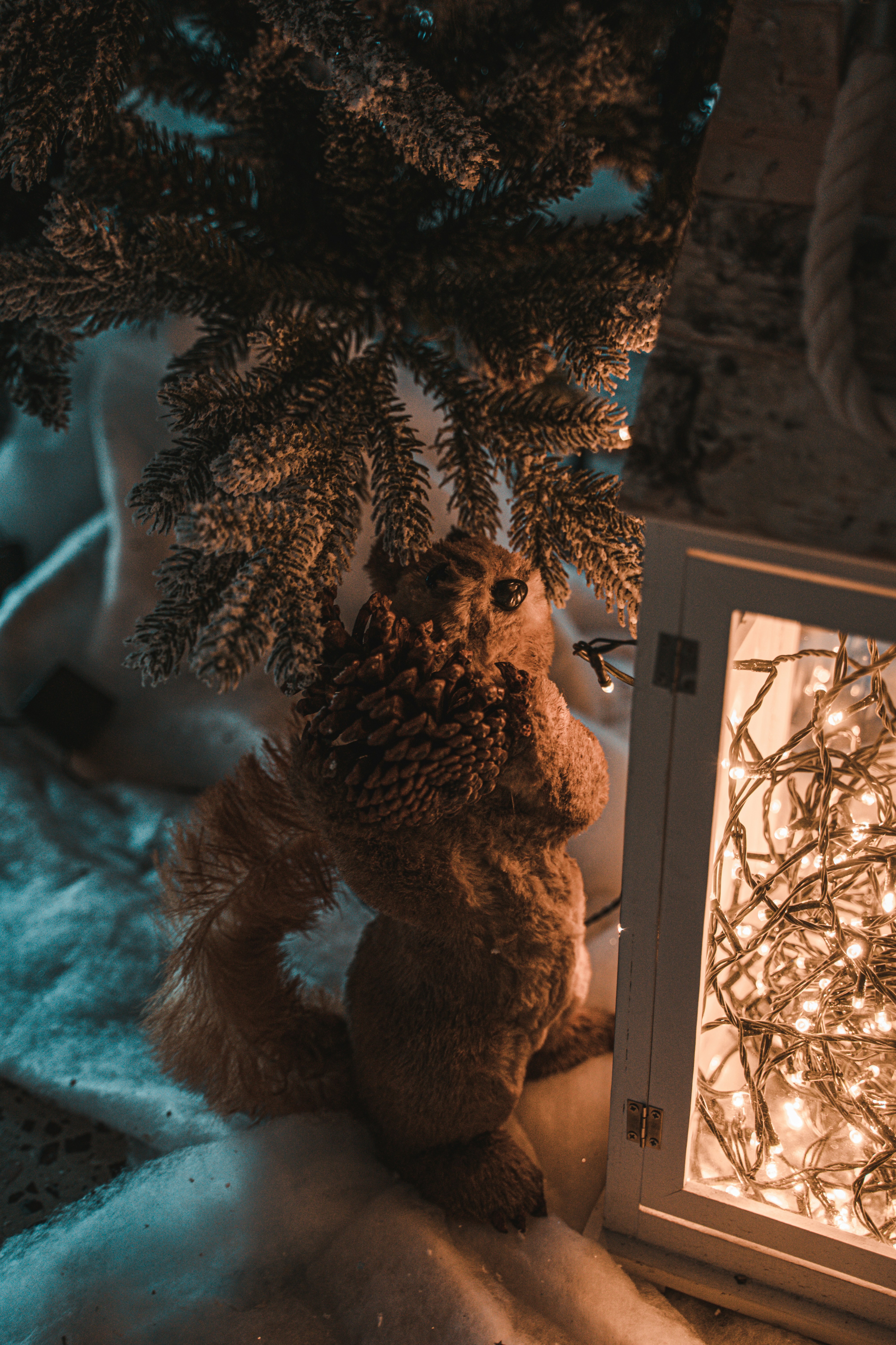 Winter Vigil: A Plush Squirrel Stands Guard by the Lantern