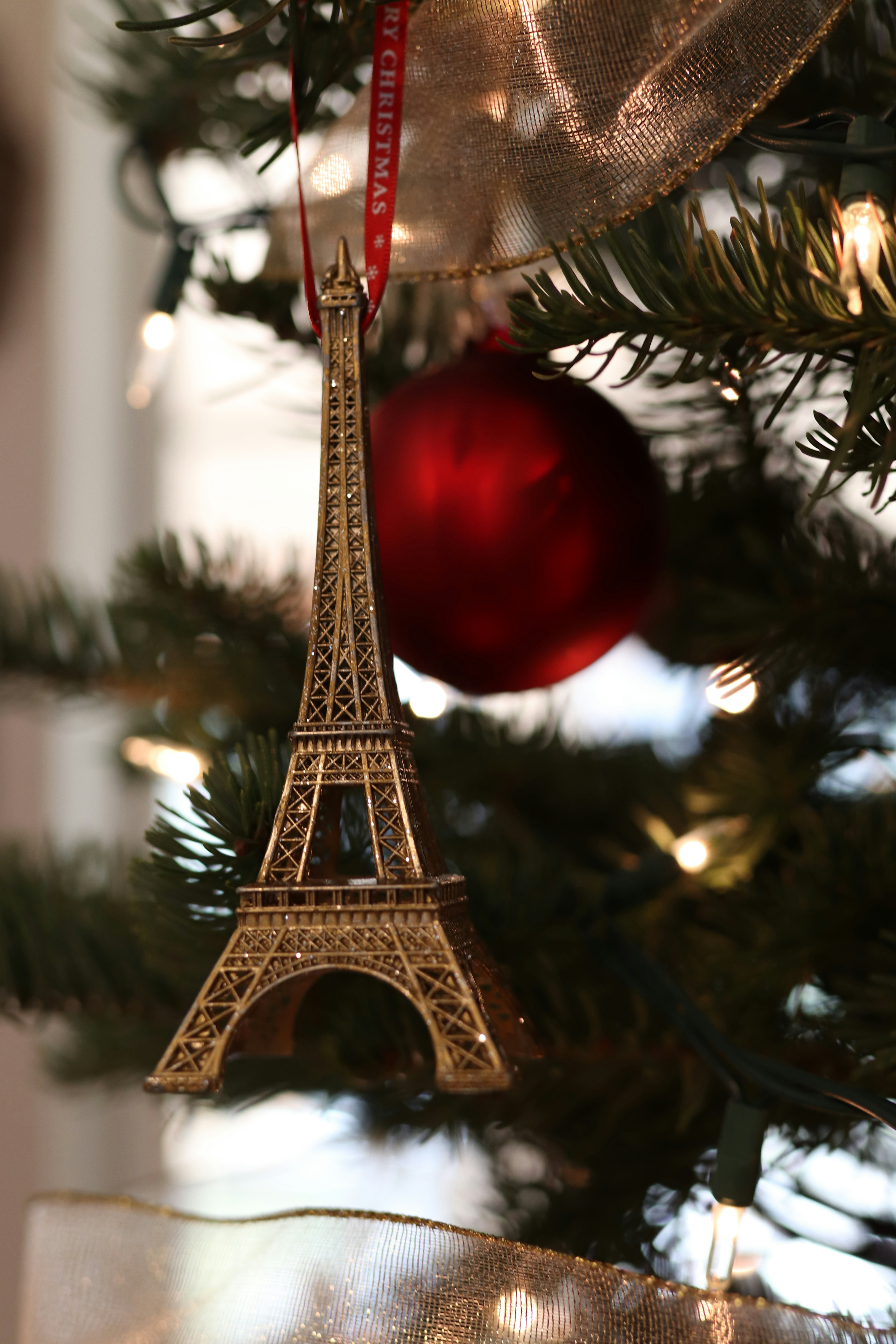 Paris on a Pine: A Miniature Eiffel Tower Ornament Amid Christmas Glow