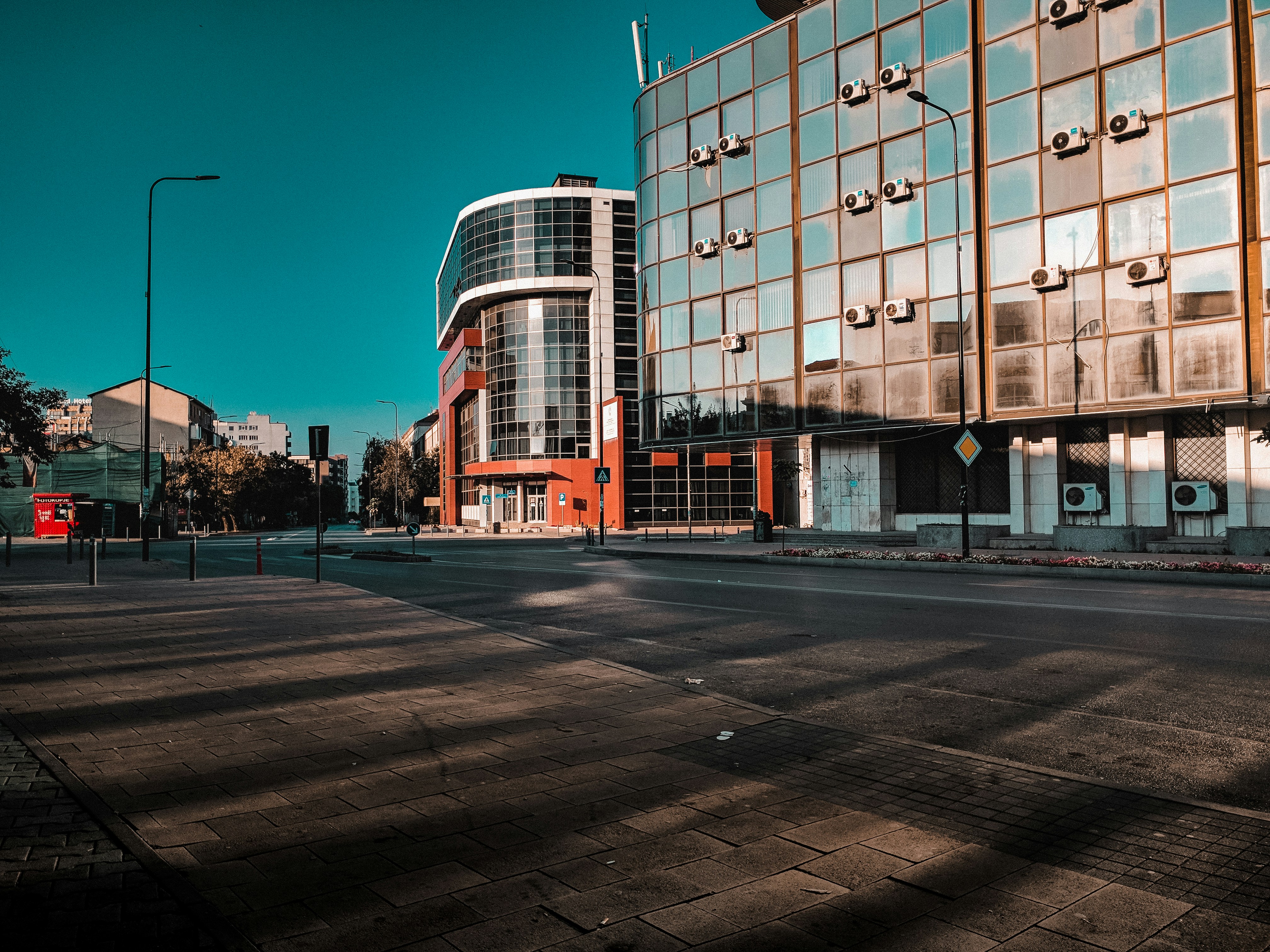 Modern buildings with reflective glass facades juxtaposed against a clear blue sky, showcasing urban architecture and design.