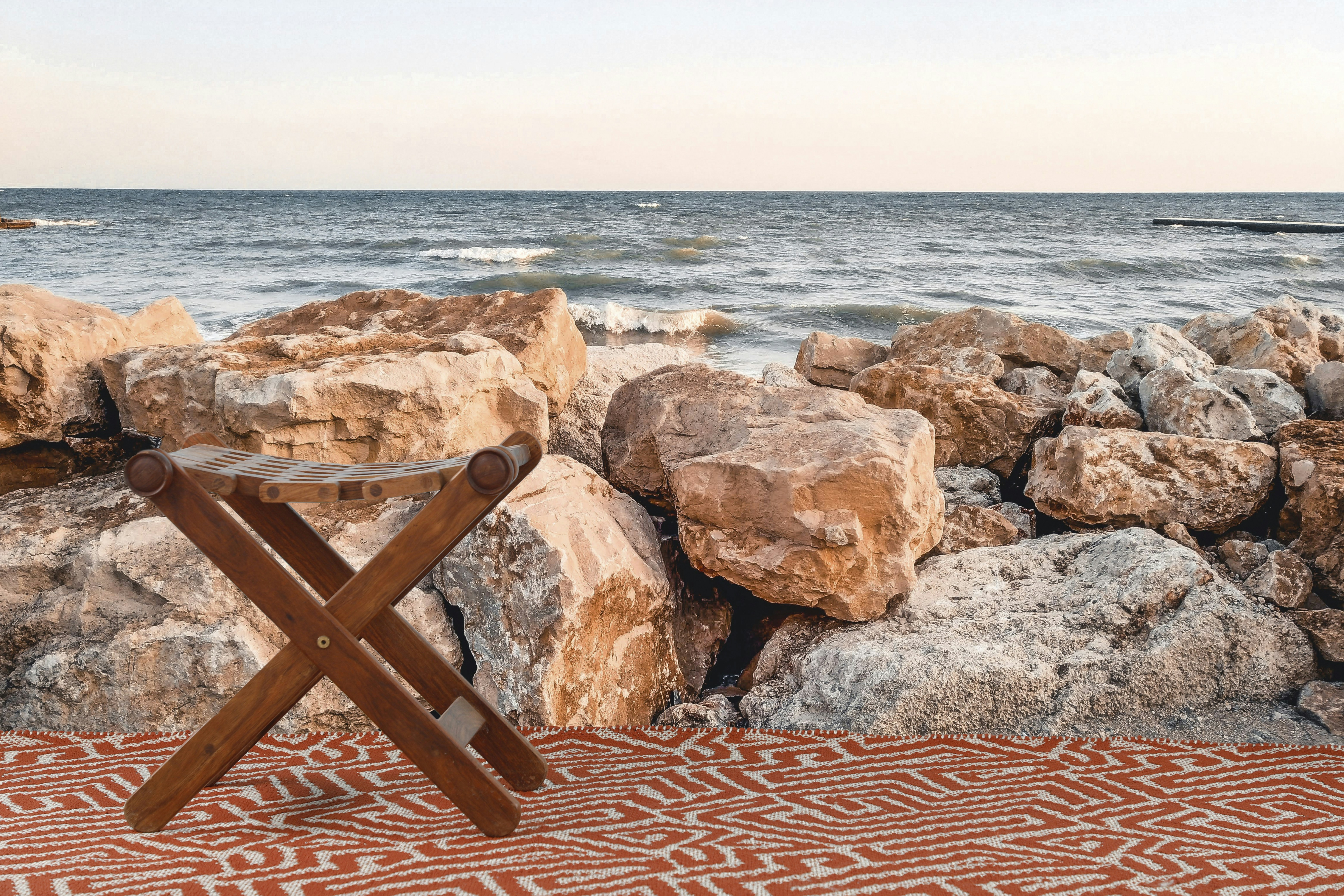 Wooden X-Chair on a Rocky Seaside Teak Rug