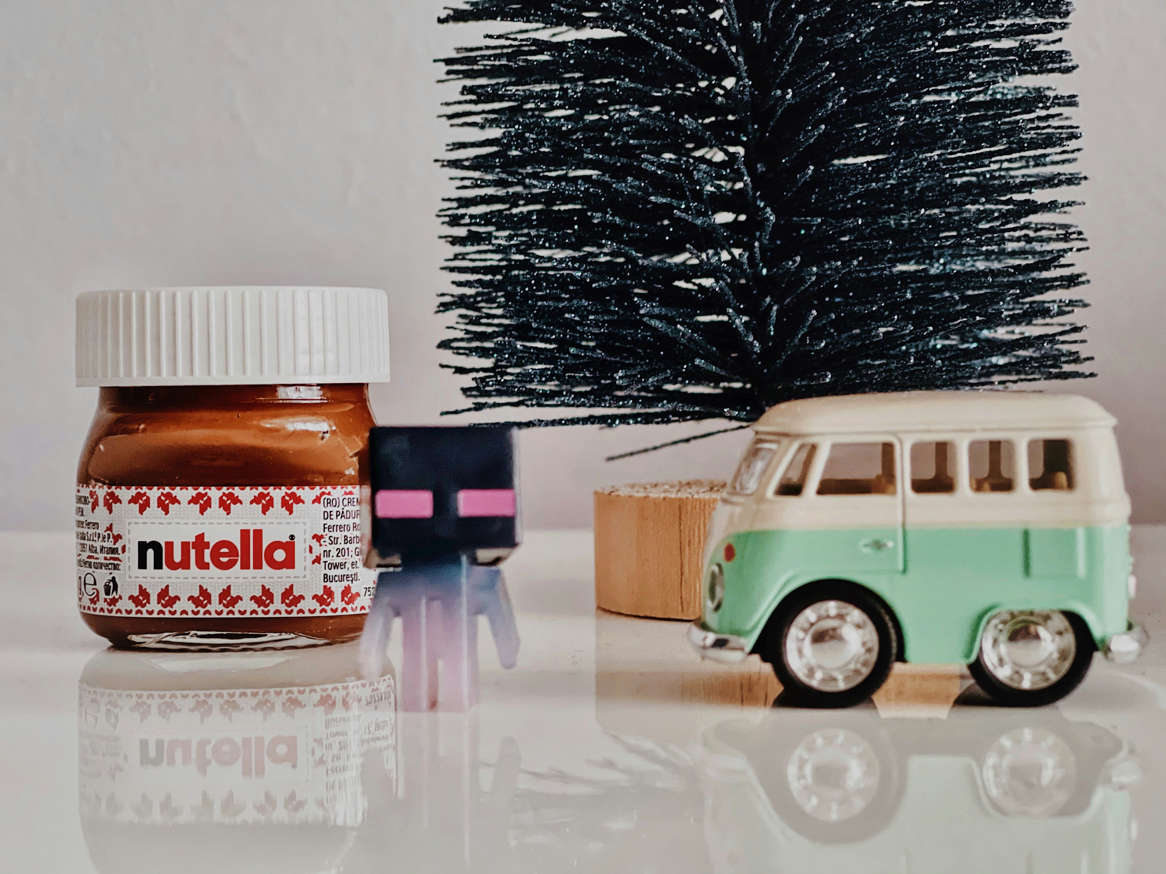 Nutella, Mini Van, and a Tiny Figure: A Reflective Still Life by a Velvet Christmas Tree