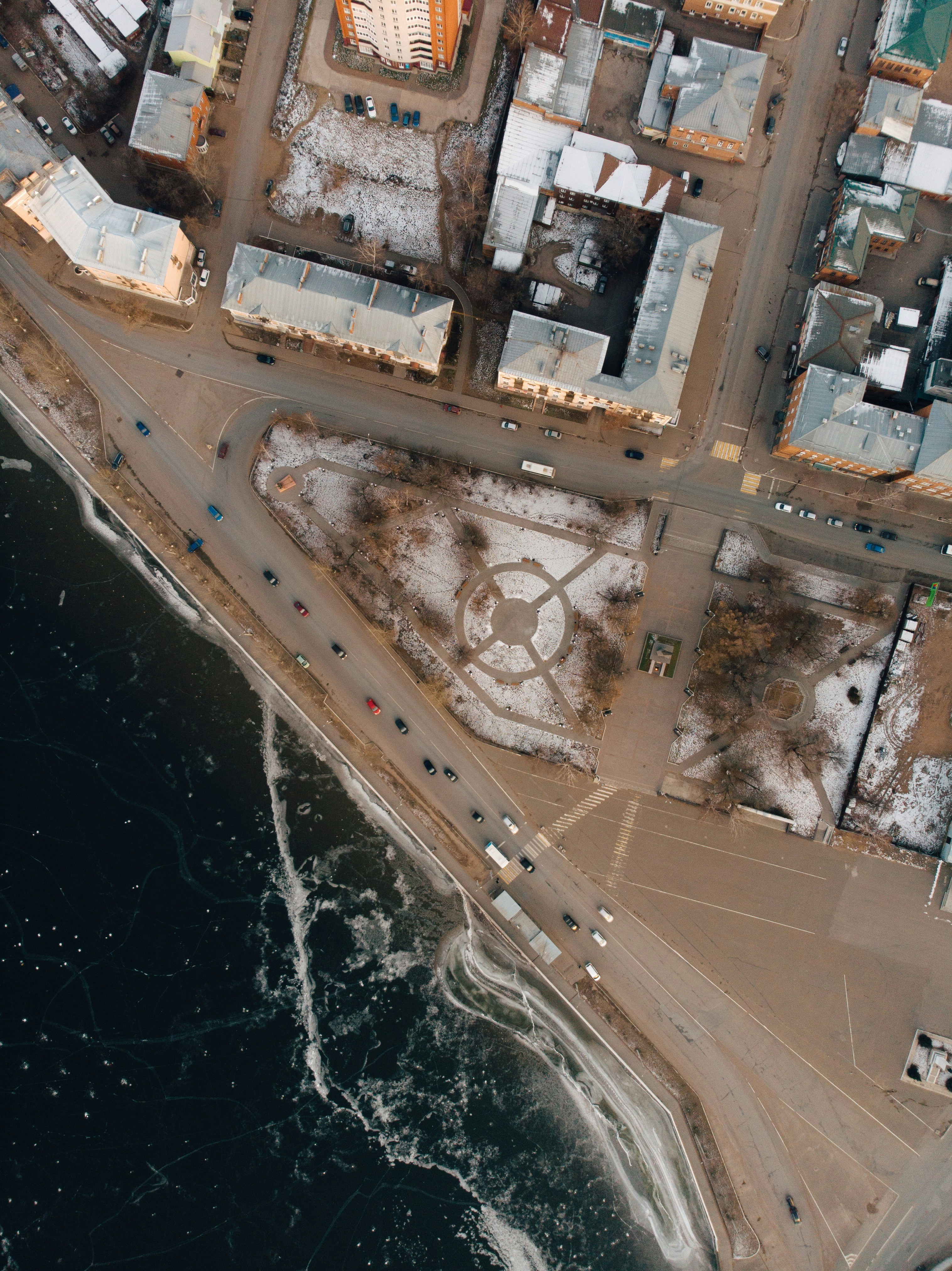 Circular Plaza at the Waterfront: Snow-Laced Aerial over a Coastal Grid