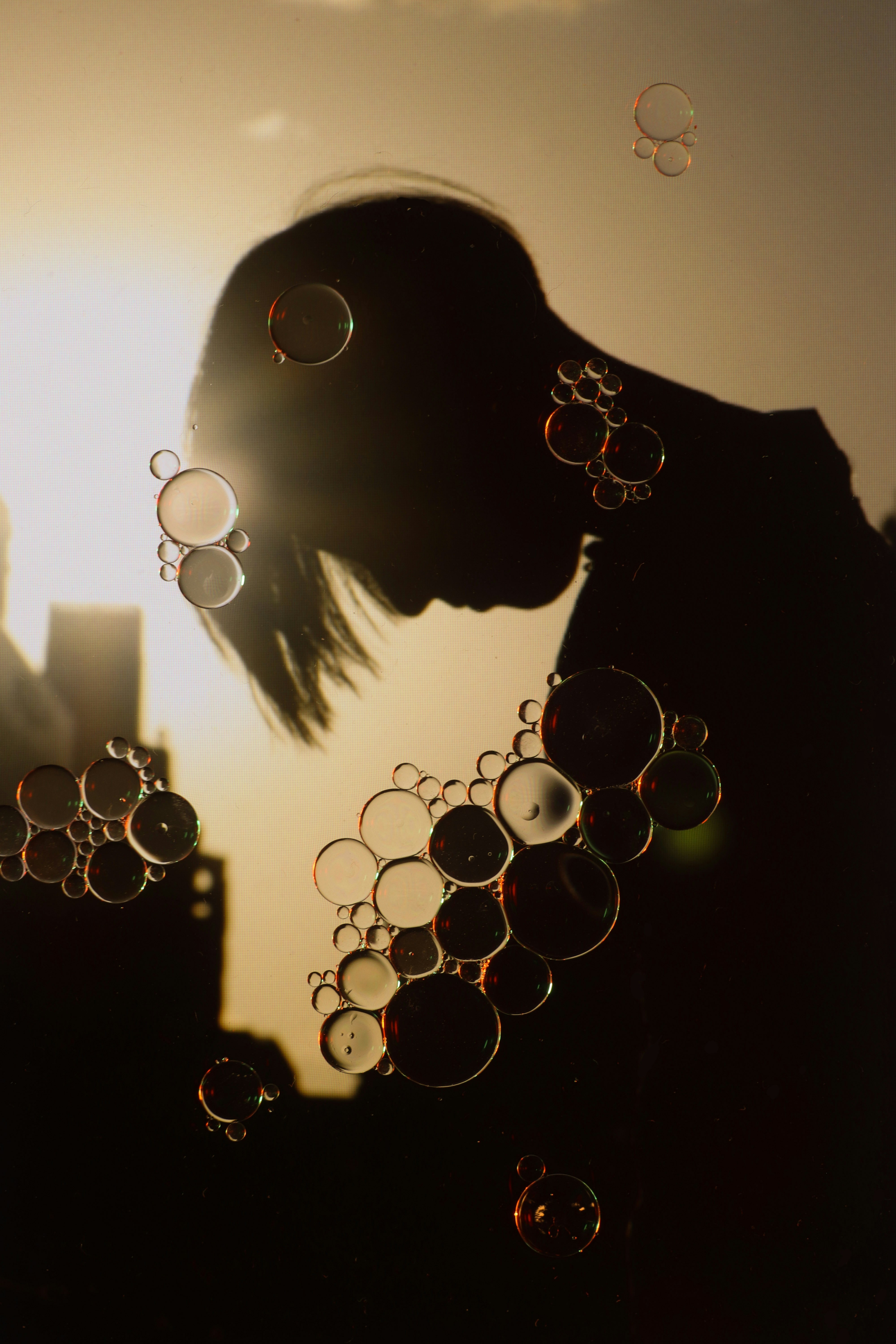 Backlit Silhouette Adrift Among Bubble Orbs