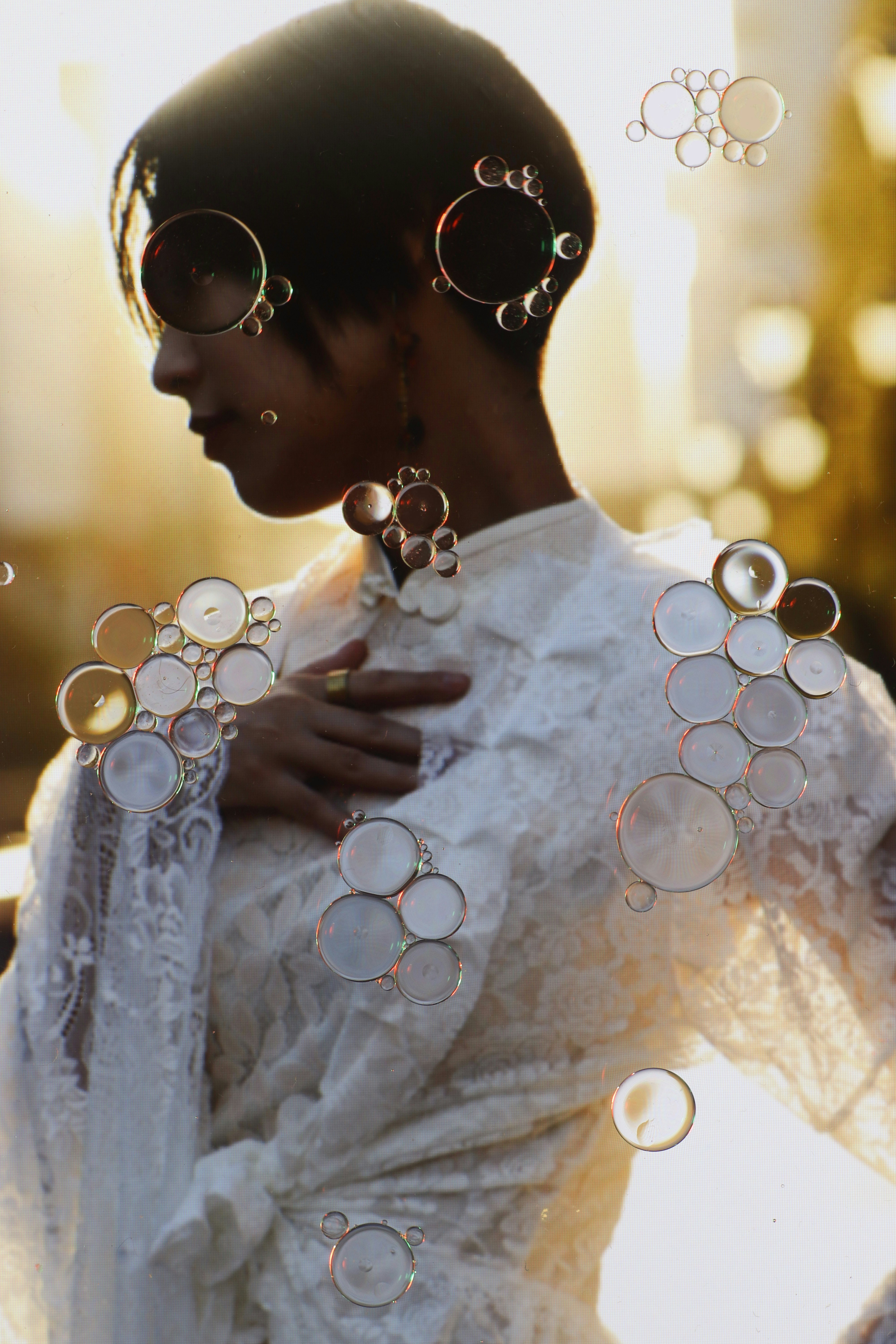 Lace in the Light: A Profile Enveloped by Floating Orbs