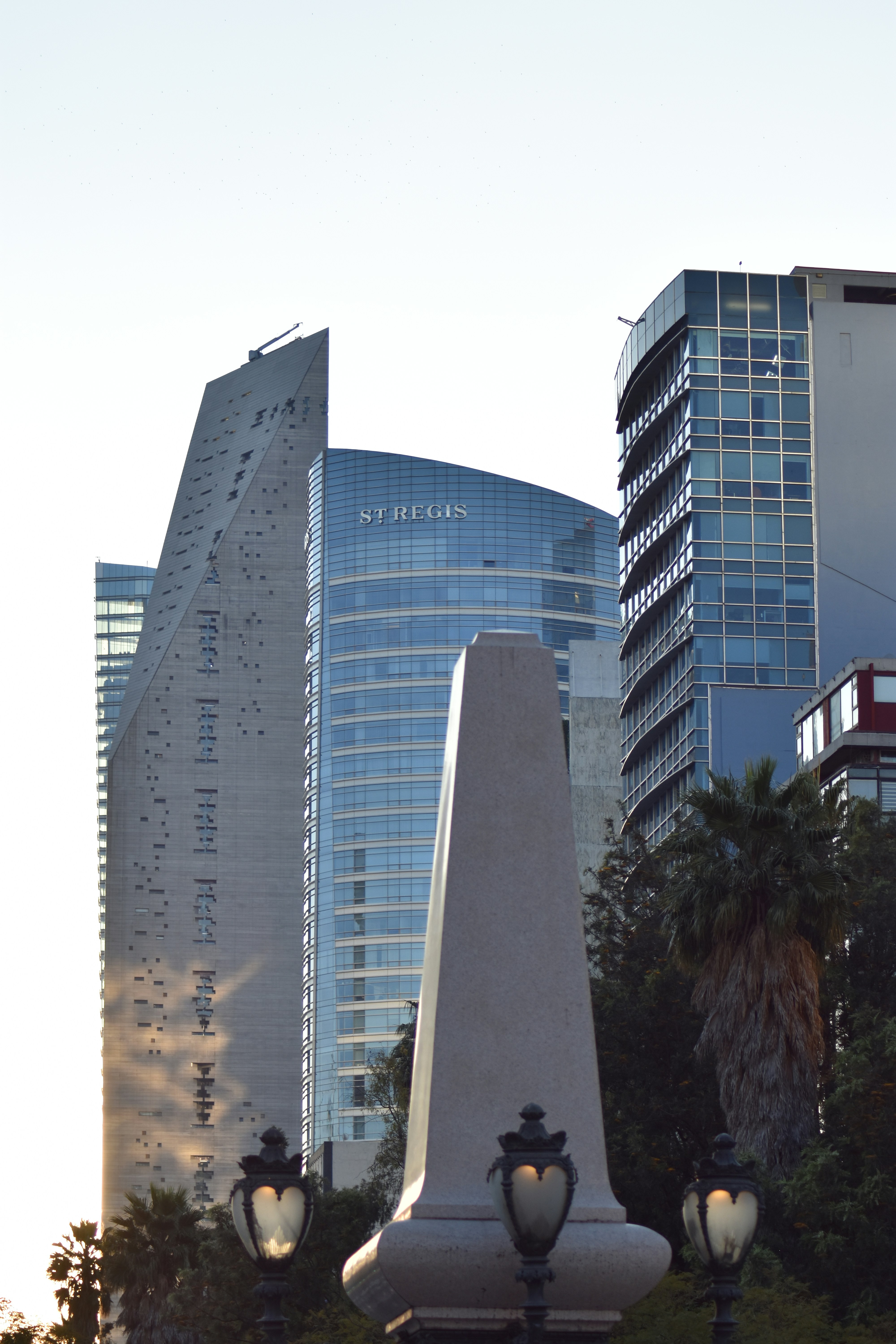 A striking view of contemporary skyscrapers juxtaposed with a classic monument, showcasing the blend of old and new in urban design.