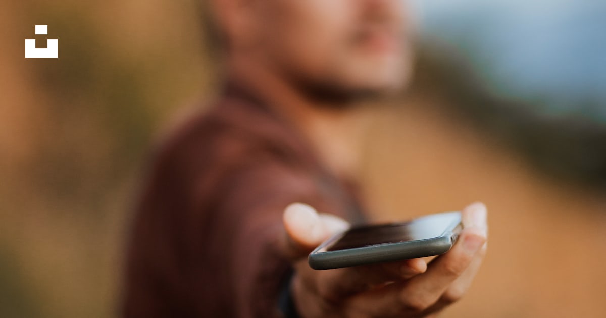 Foto Hombre Con Suéter Marrón Sosteniendo Un Teléfono Inteligente Negro