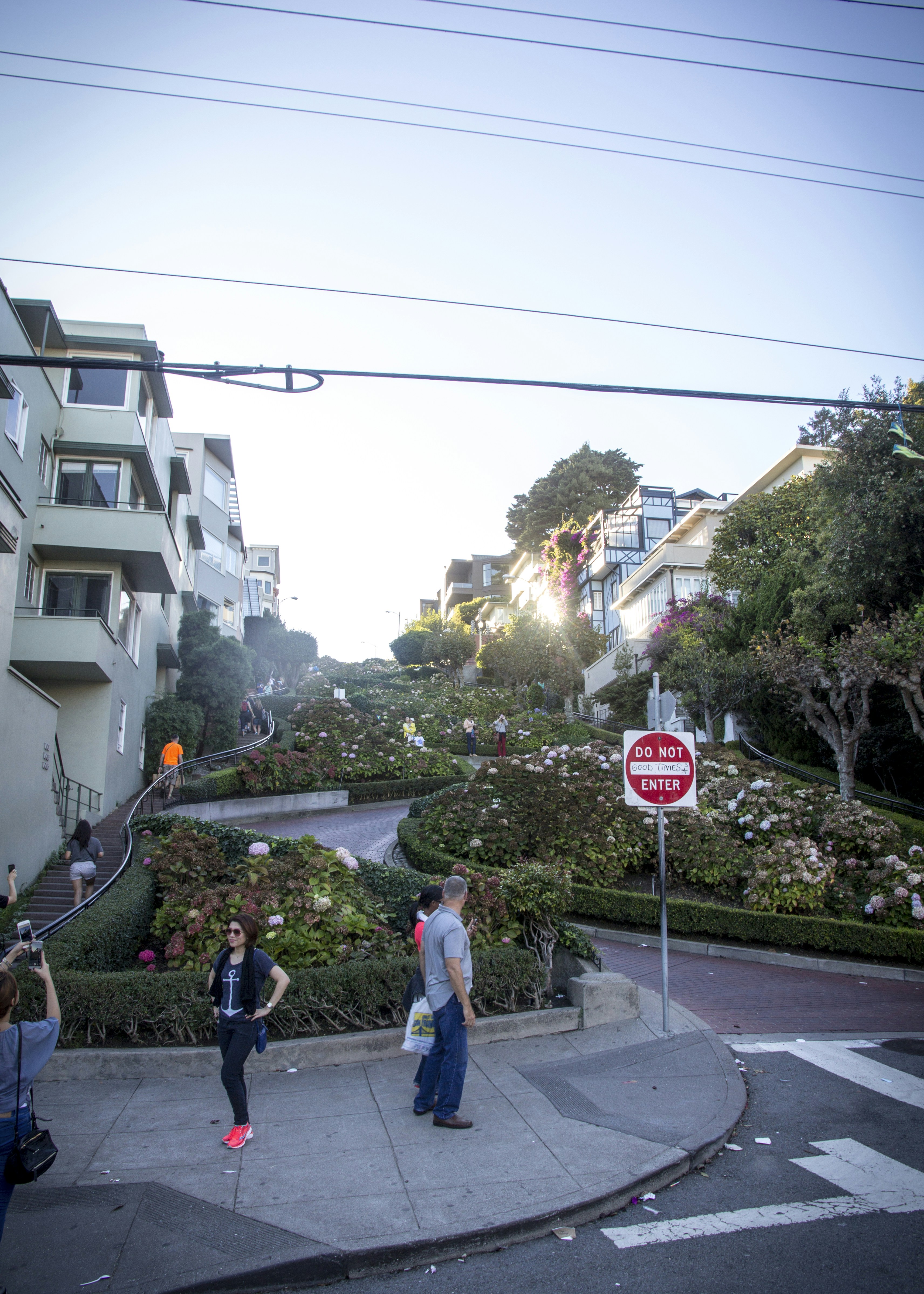 People walking on sidewalk near white concrete building during daytime ...