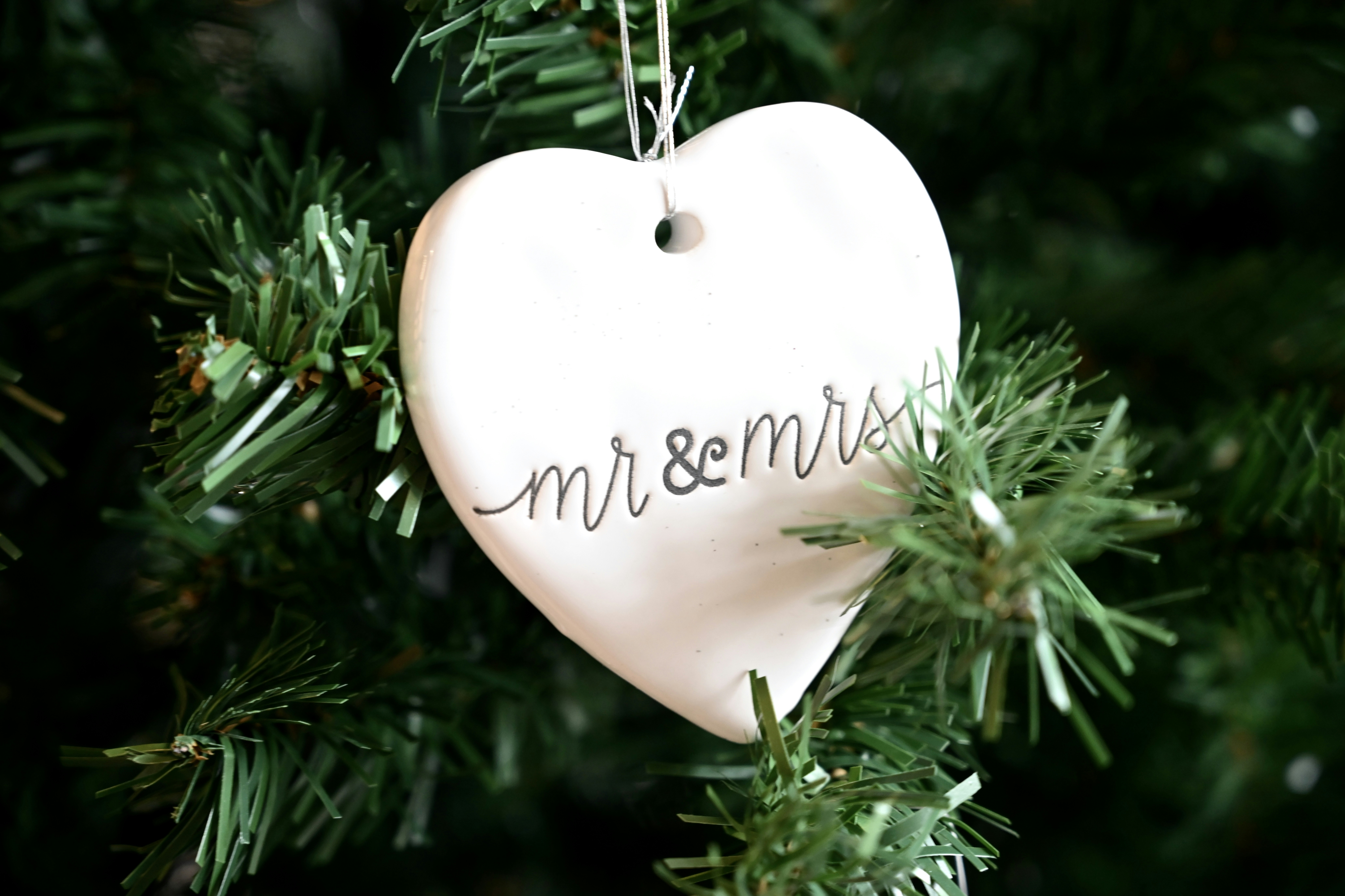 White Heart Ornament Dangles Amid Green Pines Bearing 'mr & mrs'