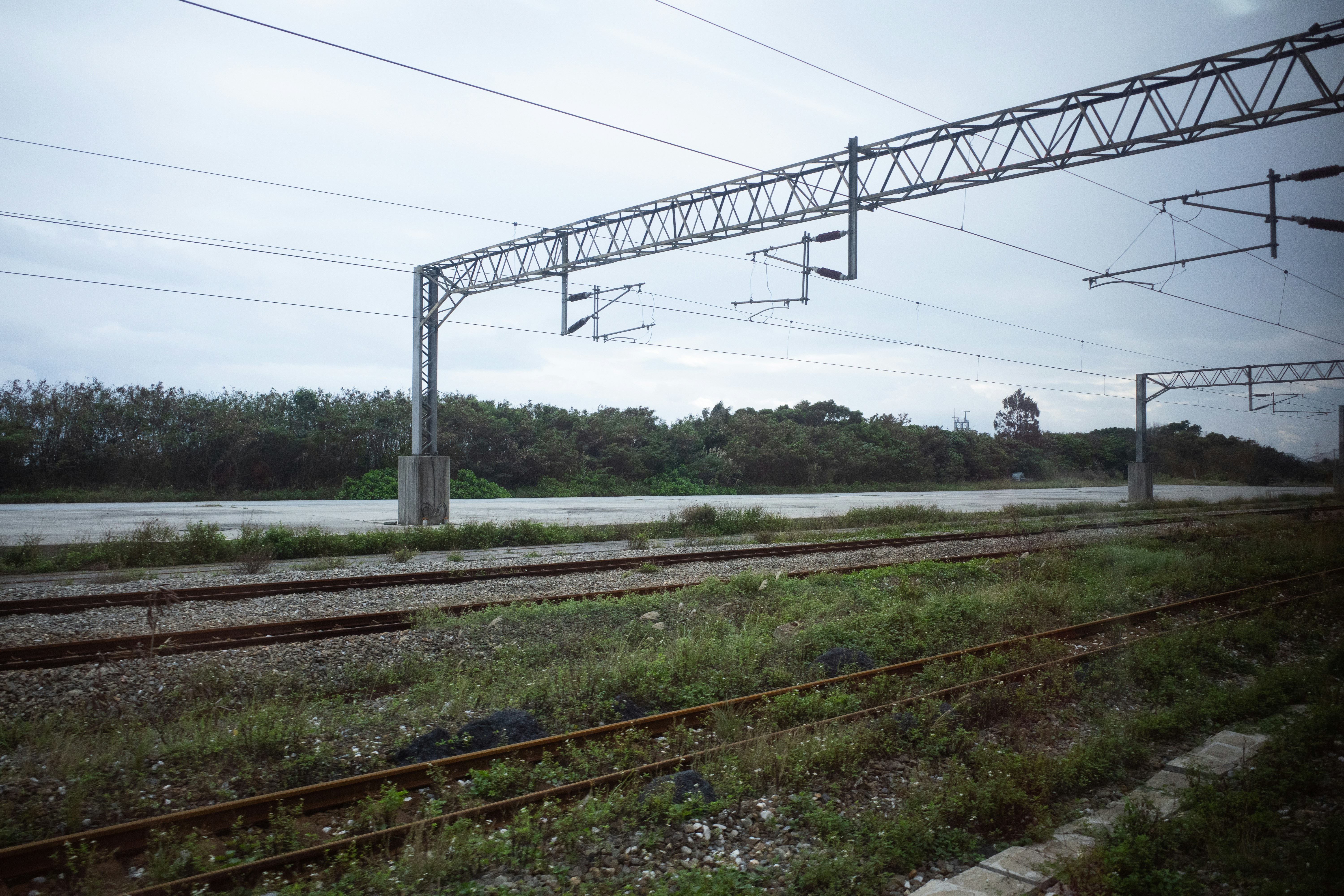 Black metal electric post near green trees under white sky during ...