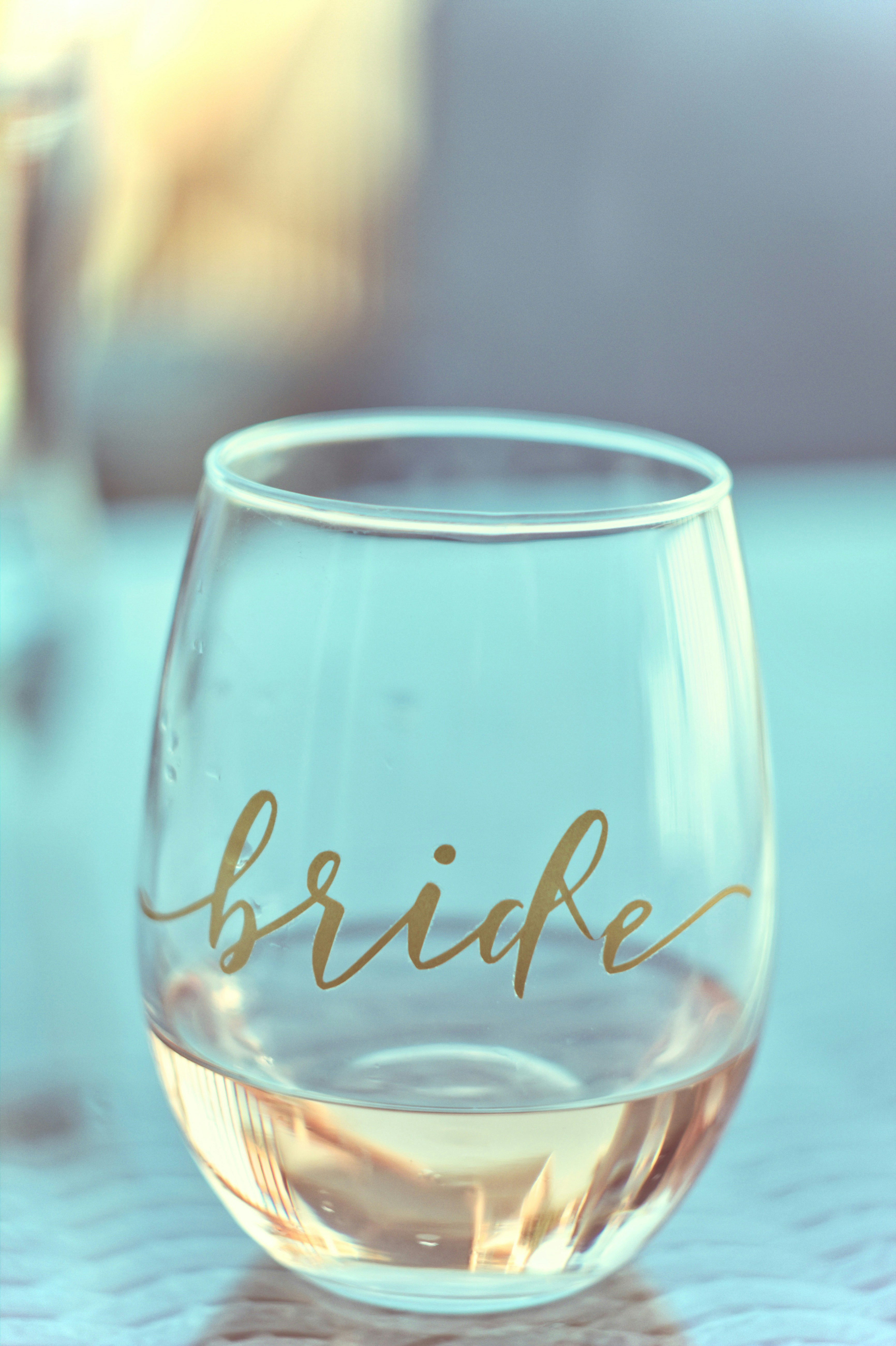 Bride Script on a Teal Glass: Close-Up of a Subtle Wedding Toast
