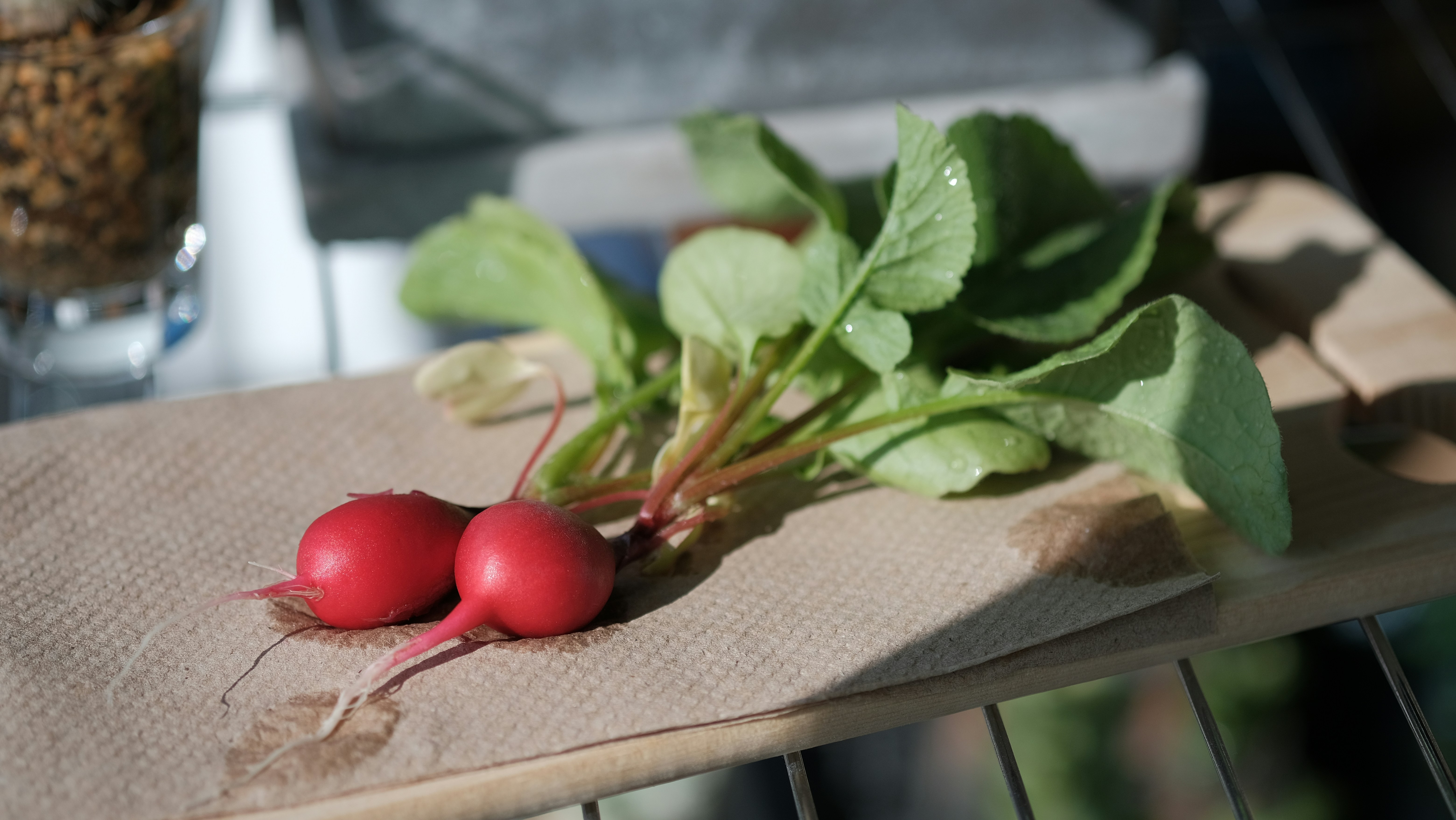 Crimson Radishes on a Textured Wooden Board with Fresh Green Foliage