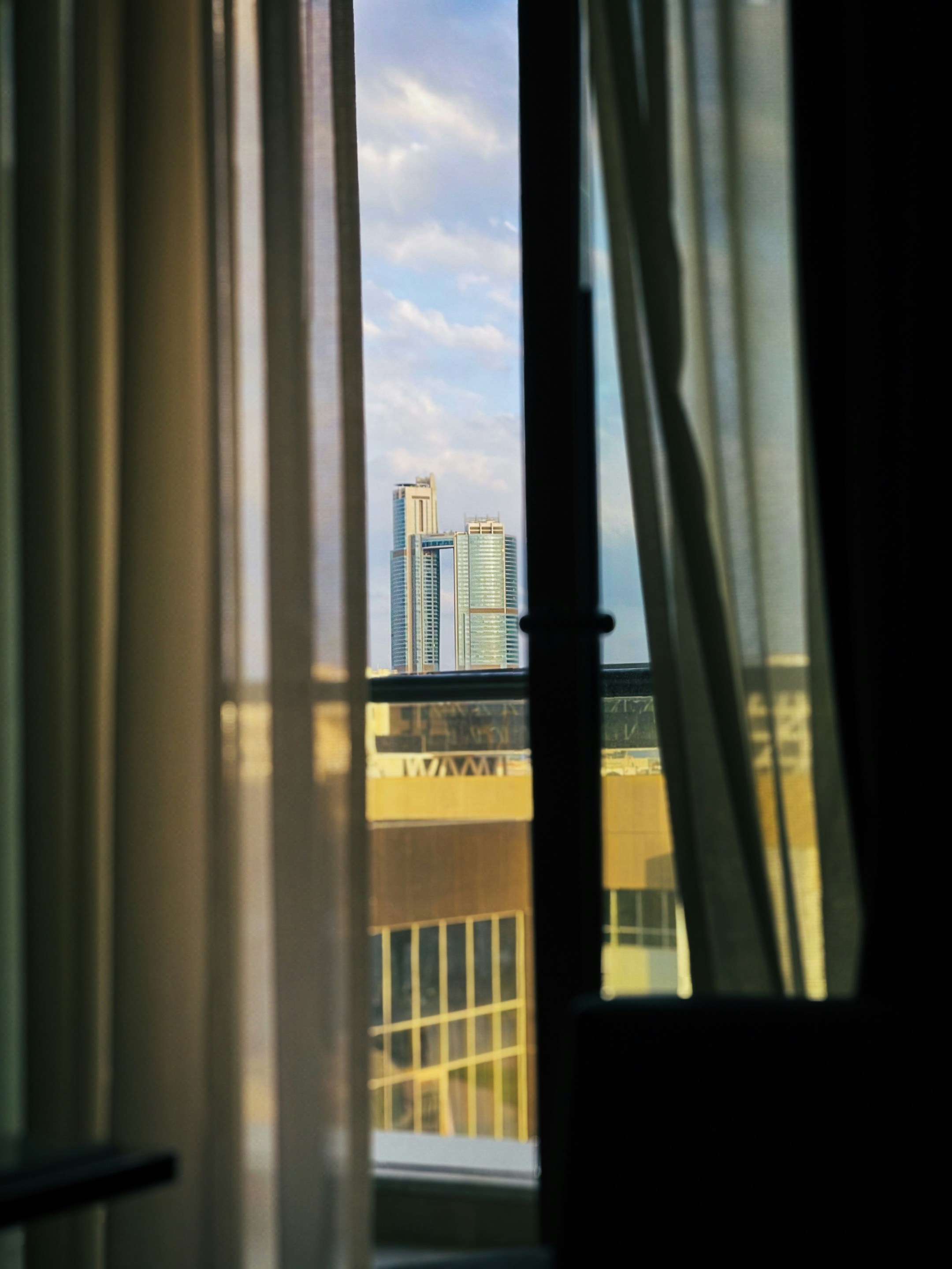Between Curtain Gaps: Morning Towers in Soft City Light