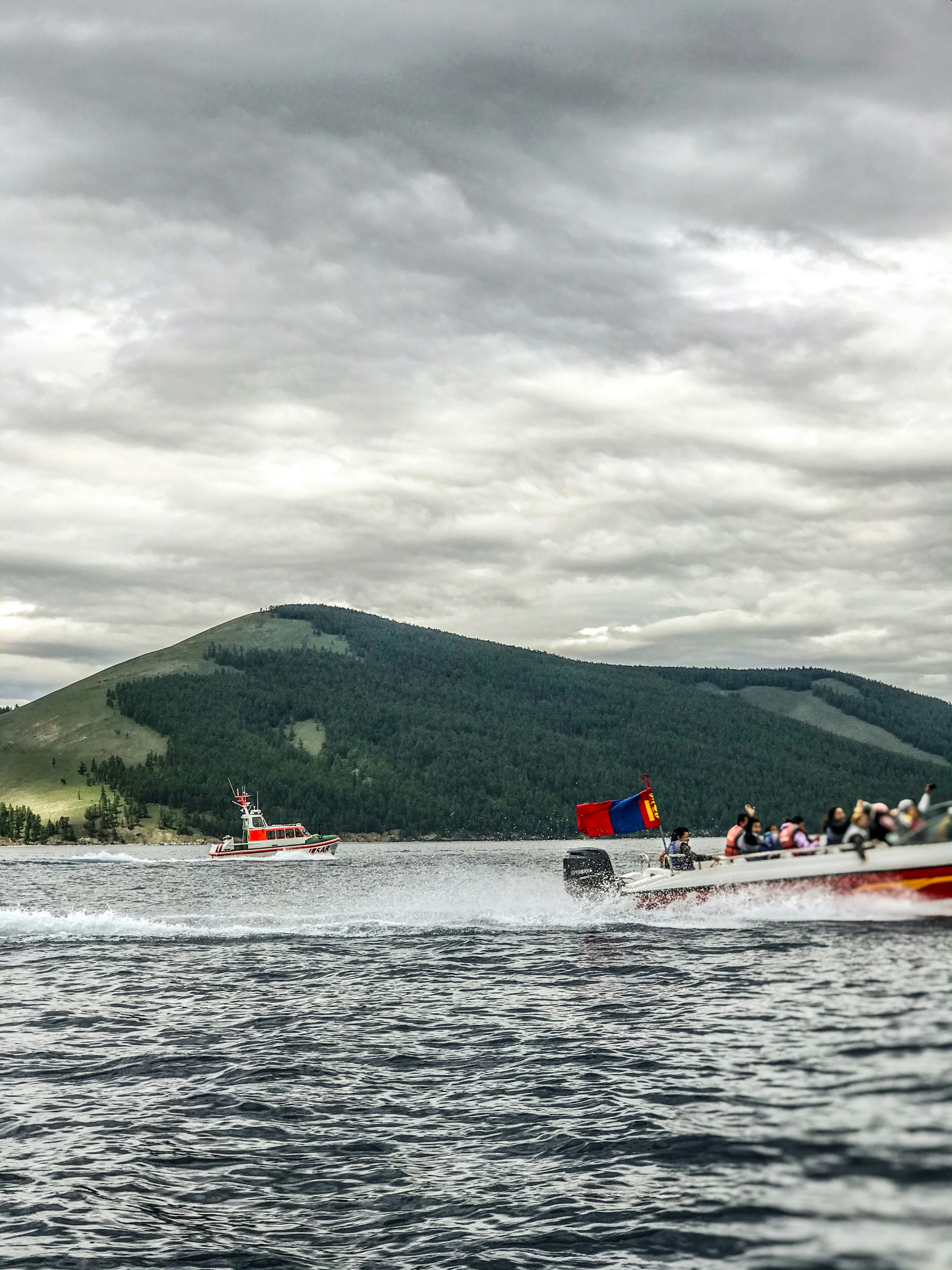 Wake Parade Over a Highland Lake: Speedboats Slice Through Cloudy Light